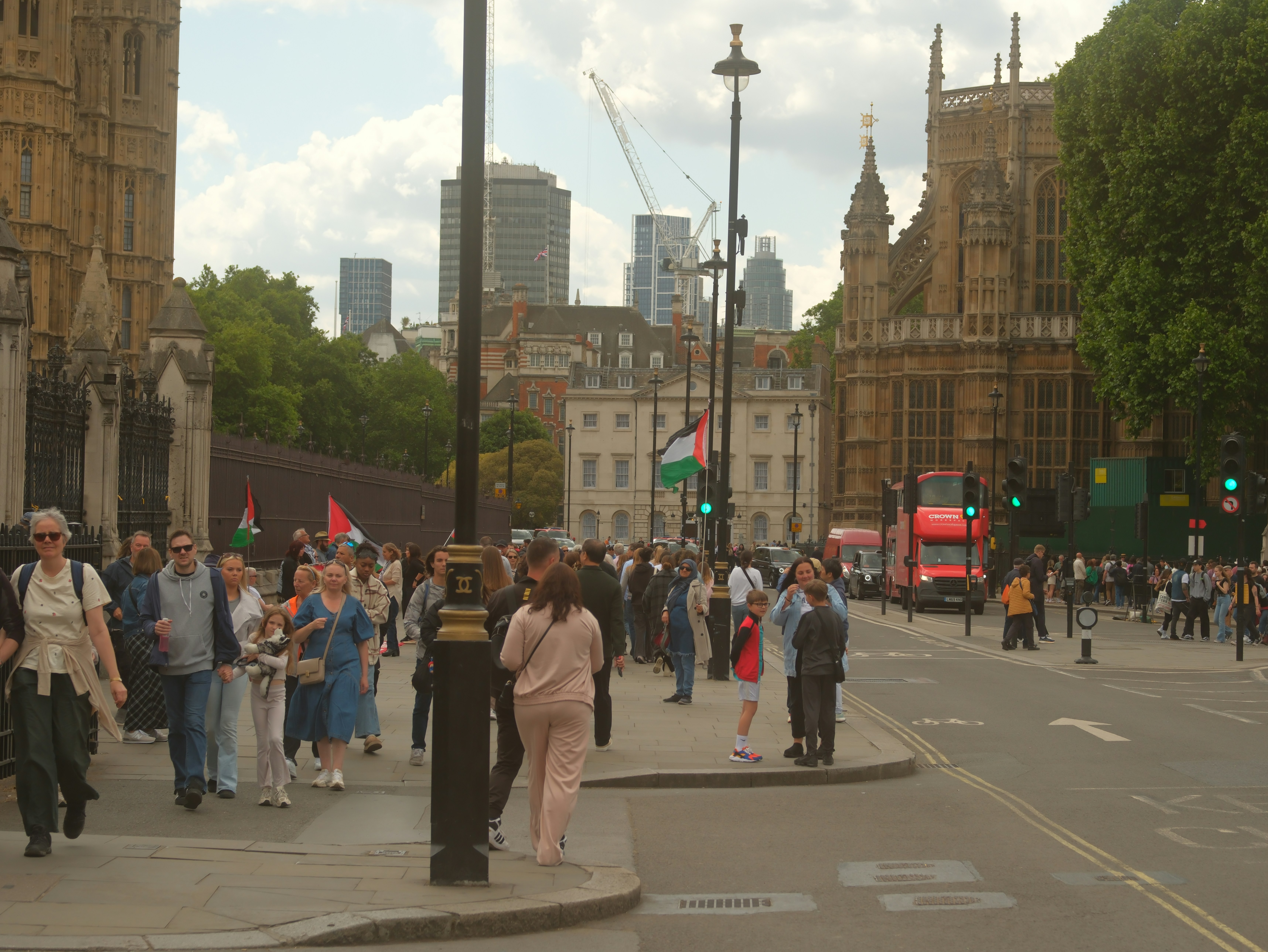 People walking on a street with a double-decker bus.