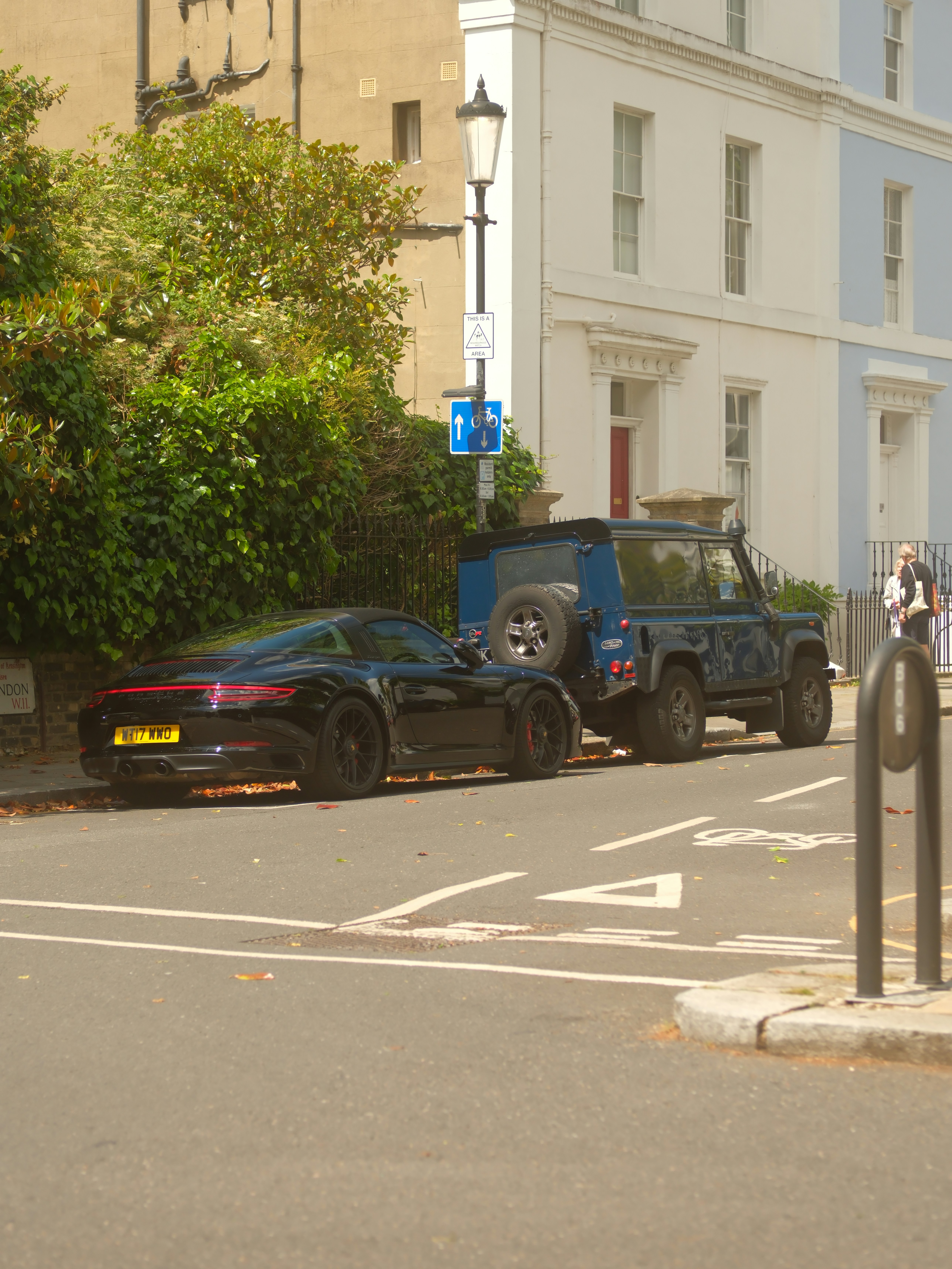 Black sports car parked next to blue suv