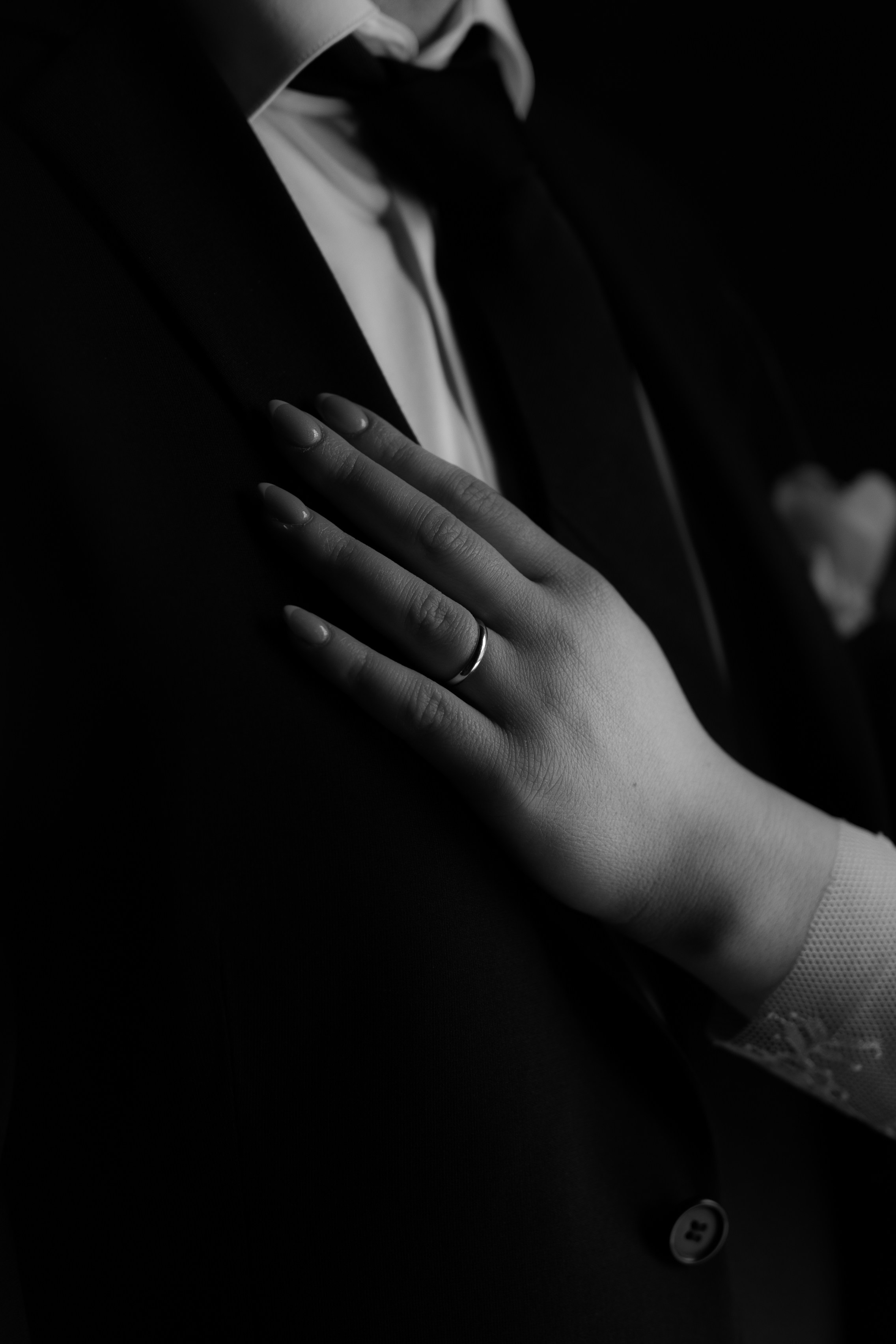 Timeless moments in black and white | Woman's hand rests on man's suit jacket
