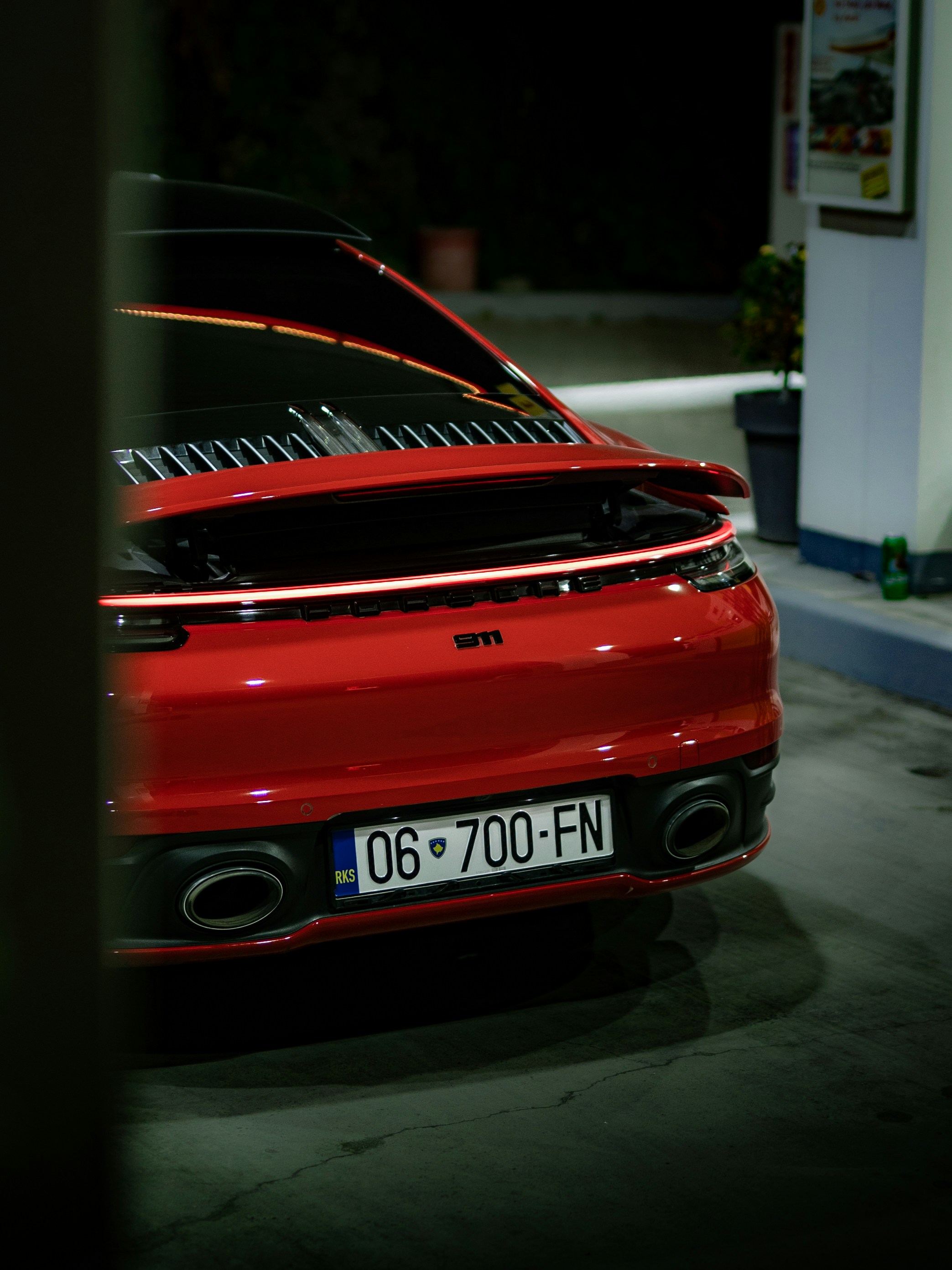 Porsche 911 | Red sports car at a gas station at night