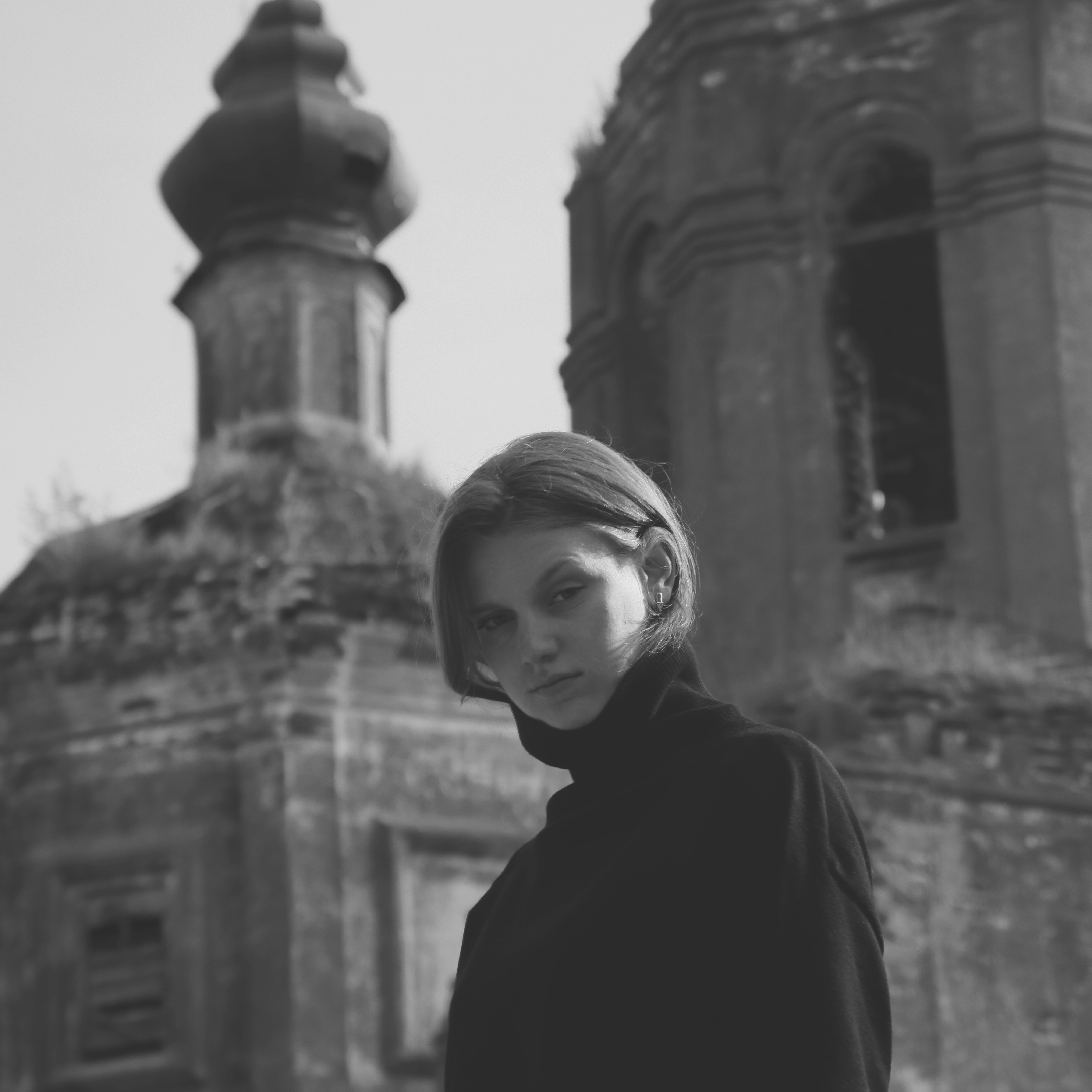 Grayscale Portrait Before Weathered Bell Towers