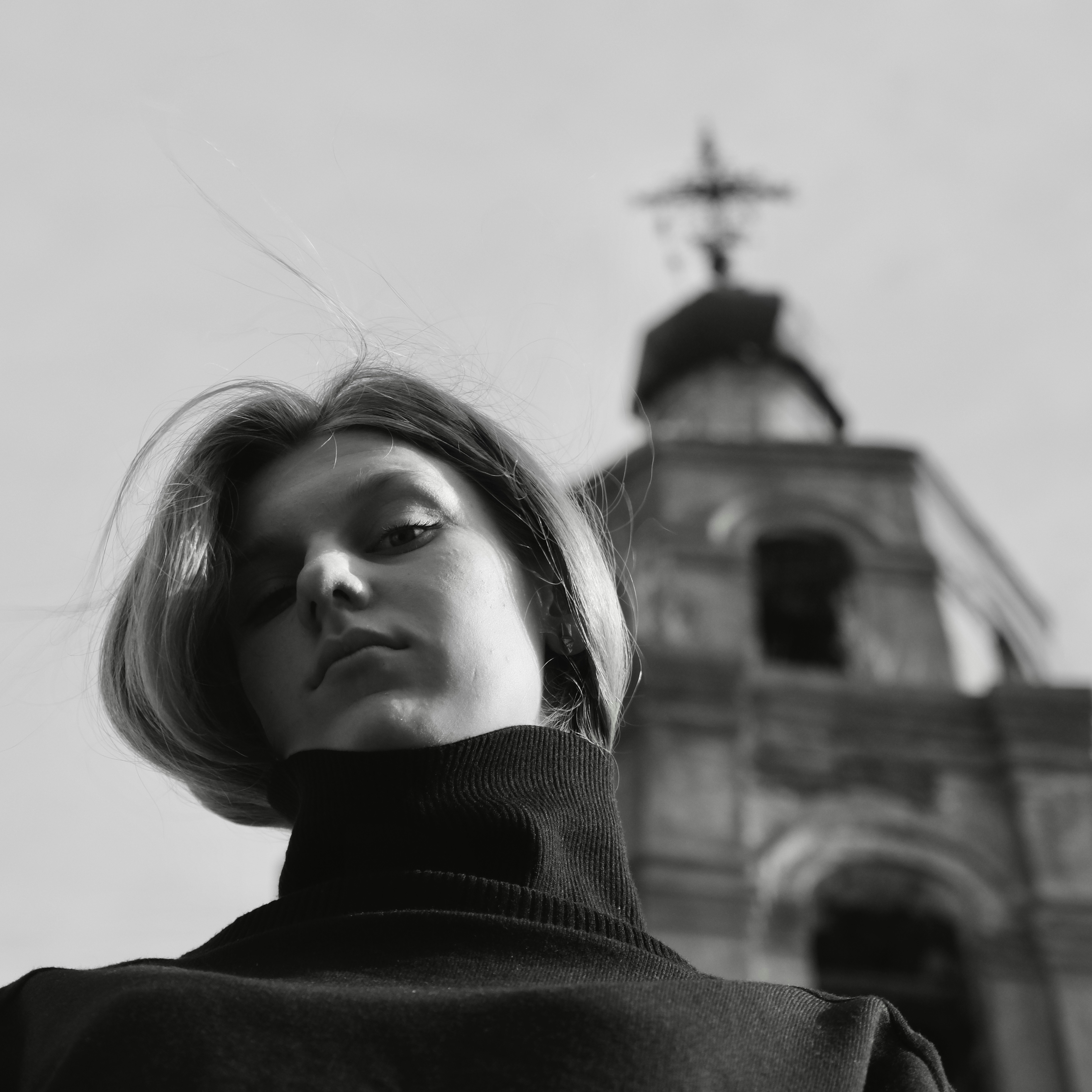 Young woman in turtleneck with building behind