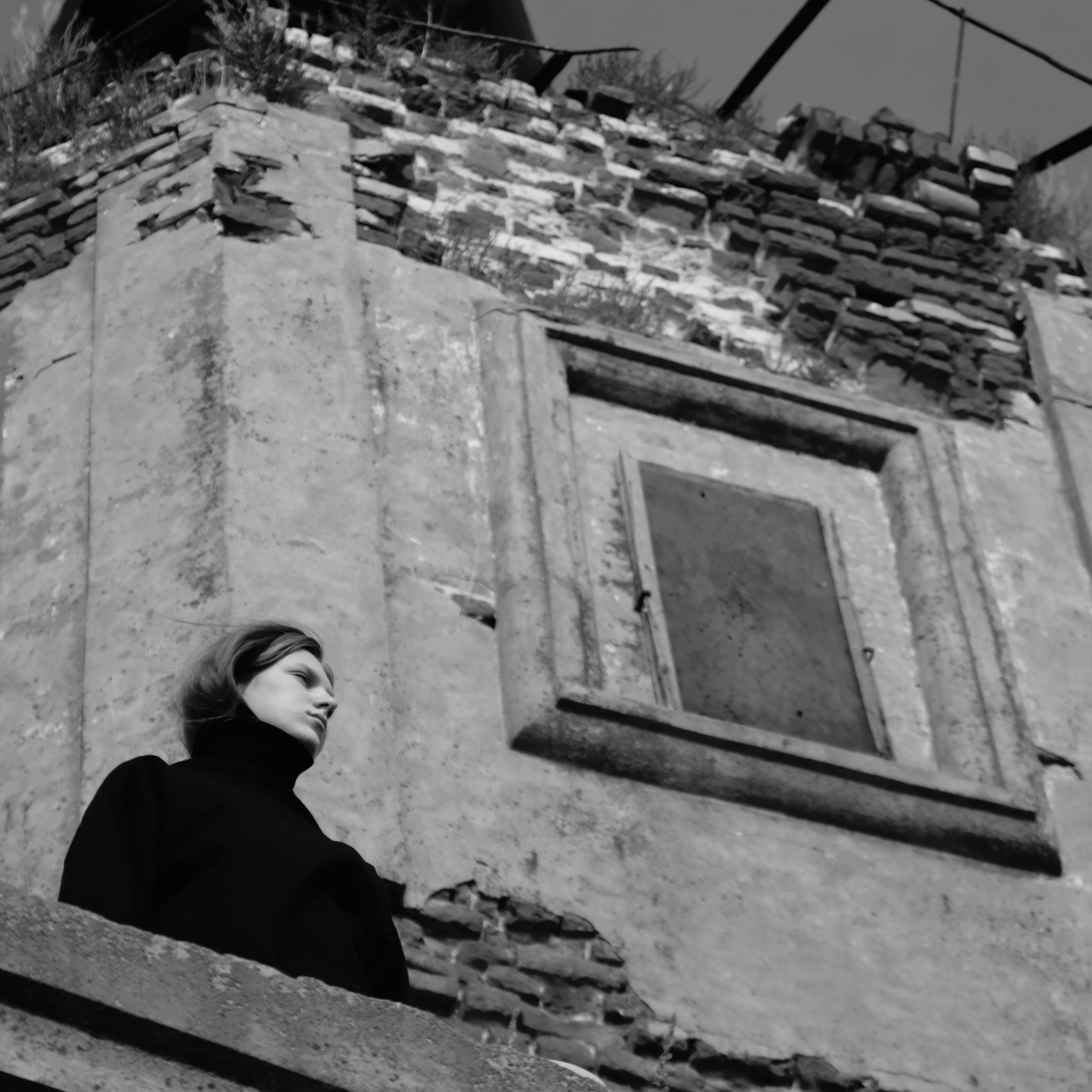 Woman looking out from old brick building