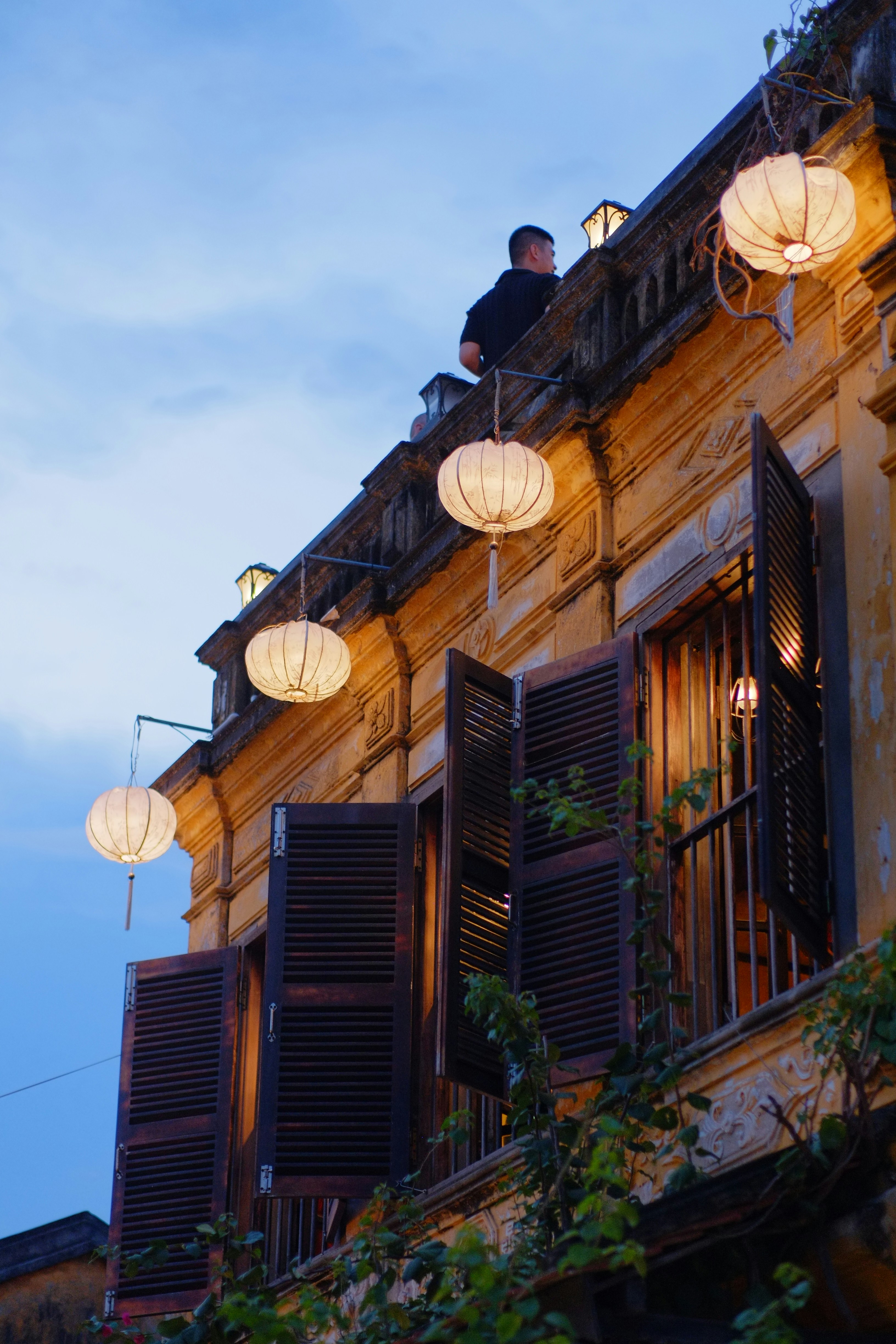 Rooftop Lanterns and Open Shutters: Dusk on a Historic Veranda