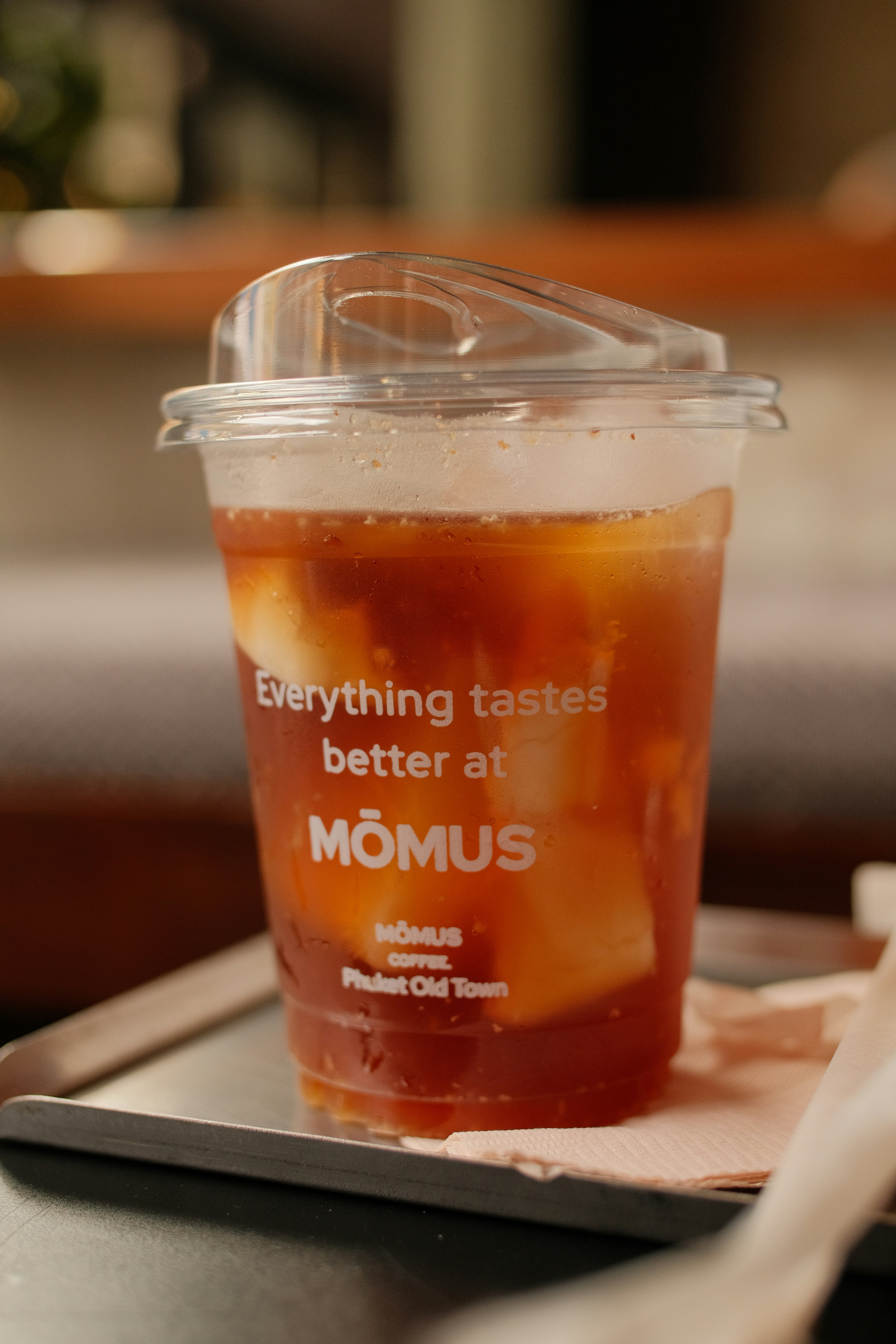 Iced tea with fruit pieces in a plastic cup