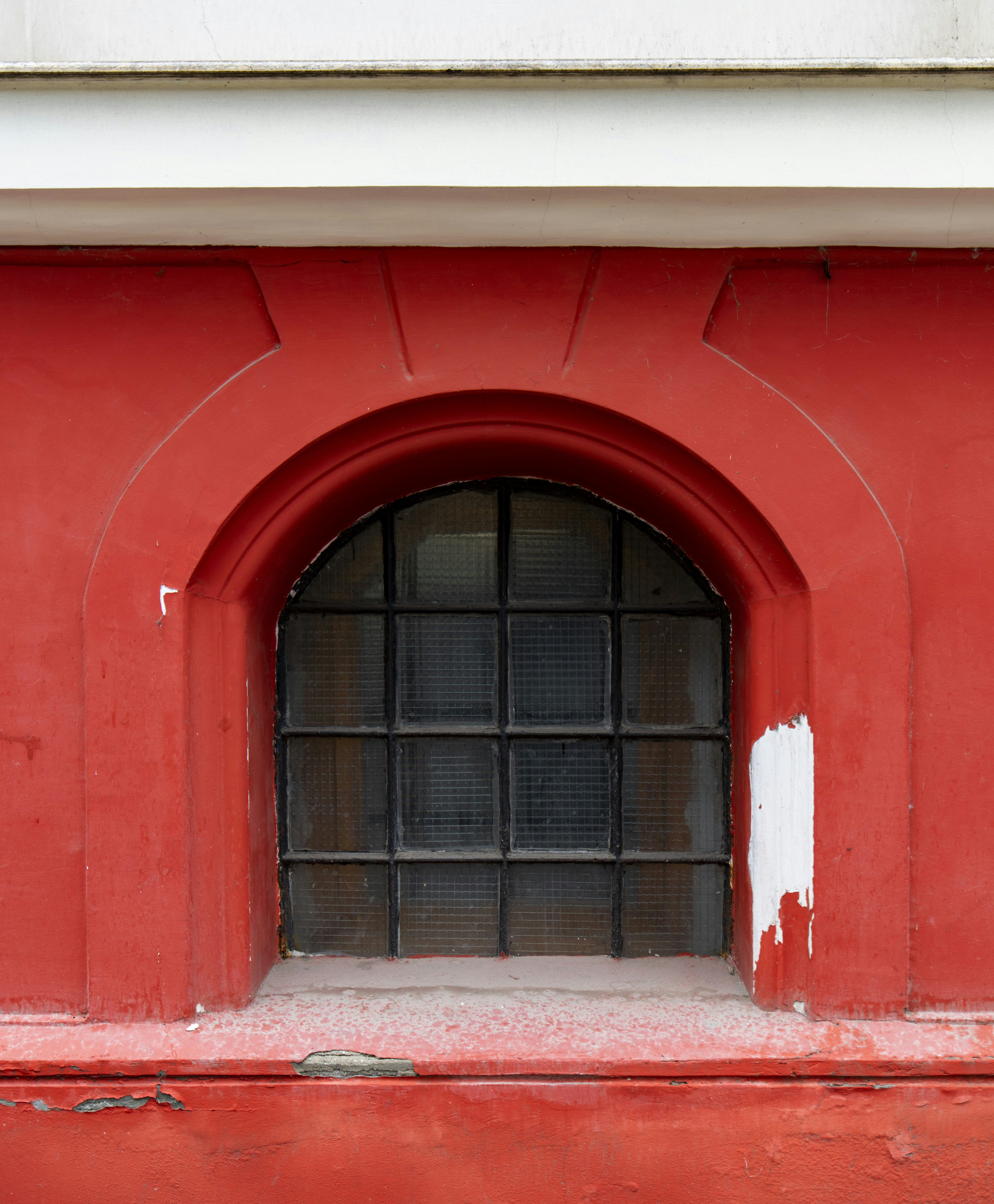 A red wall with an arched window