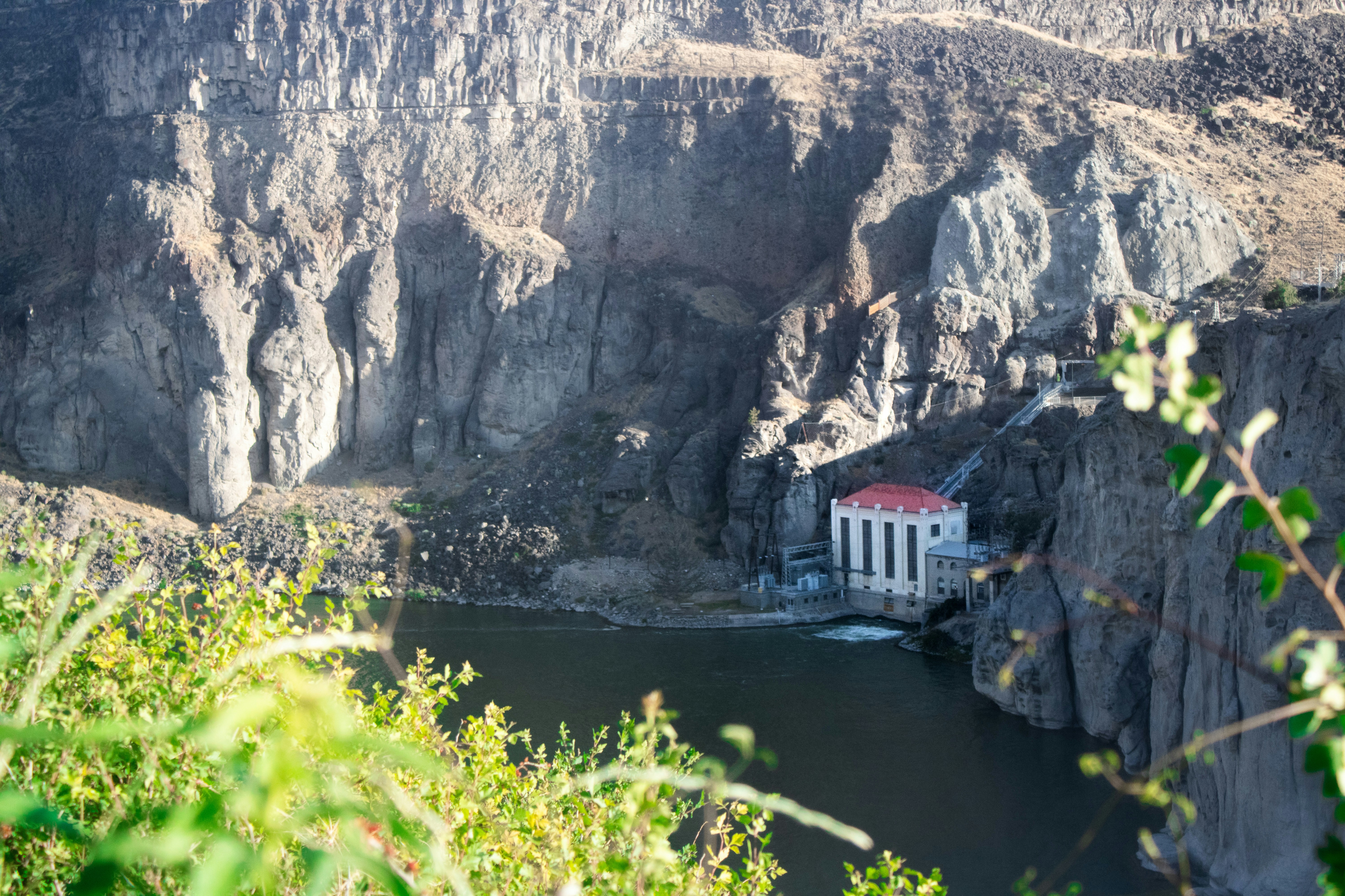Building nestled in a rocky canyon beside a river.