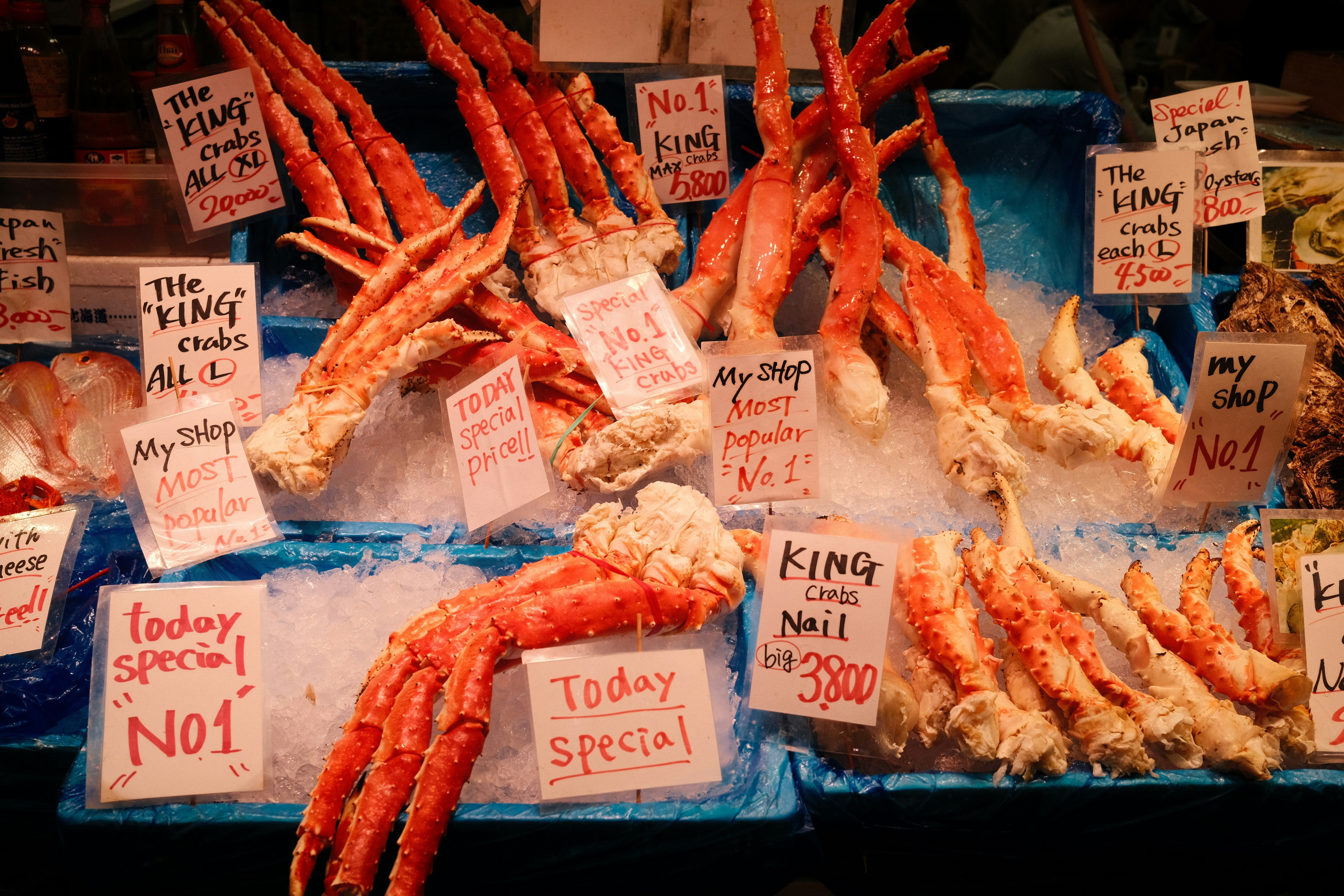 food stall at fish market in Osaka | King crab legs displayed on ice at market
