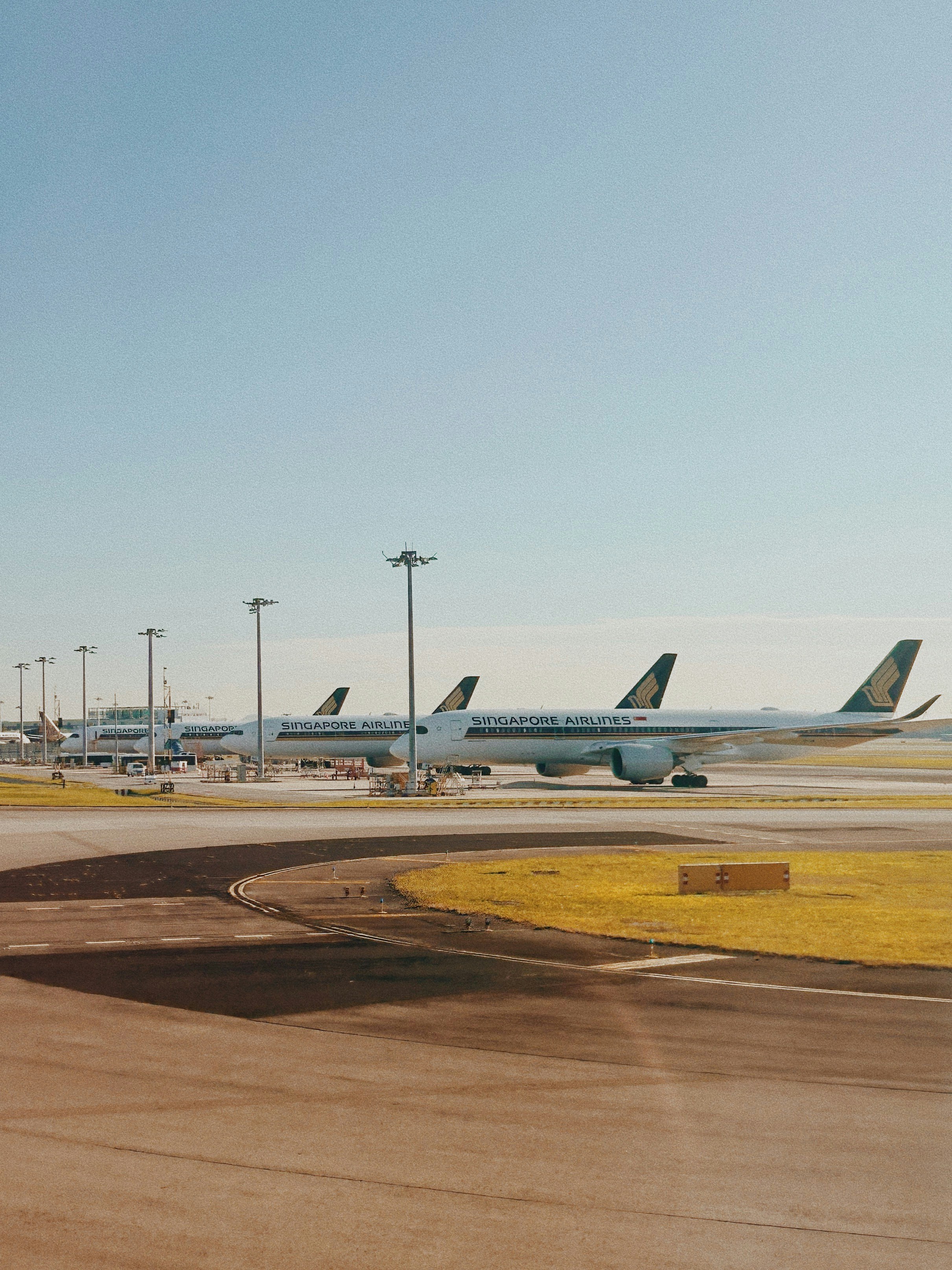 Singapore Airlines | Airplanes parked on the tarmac at an airport.