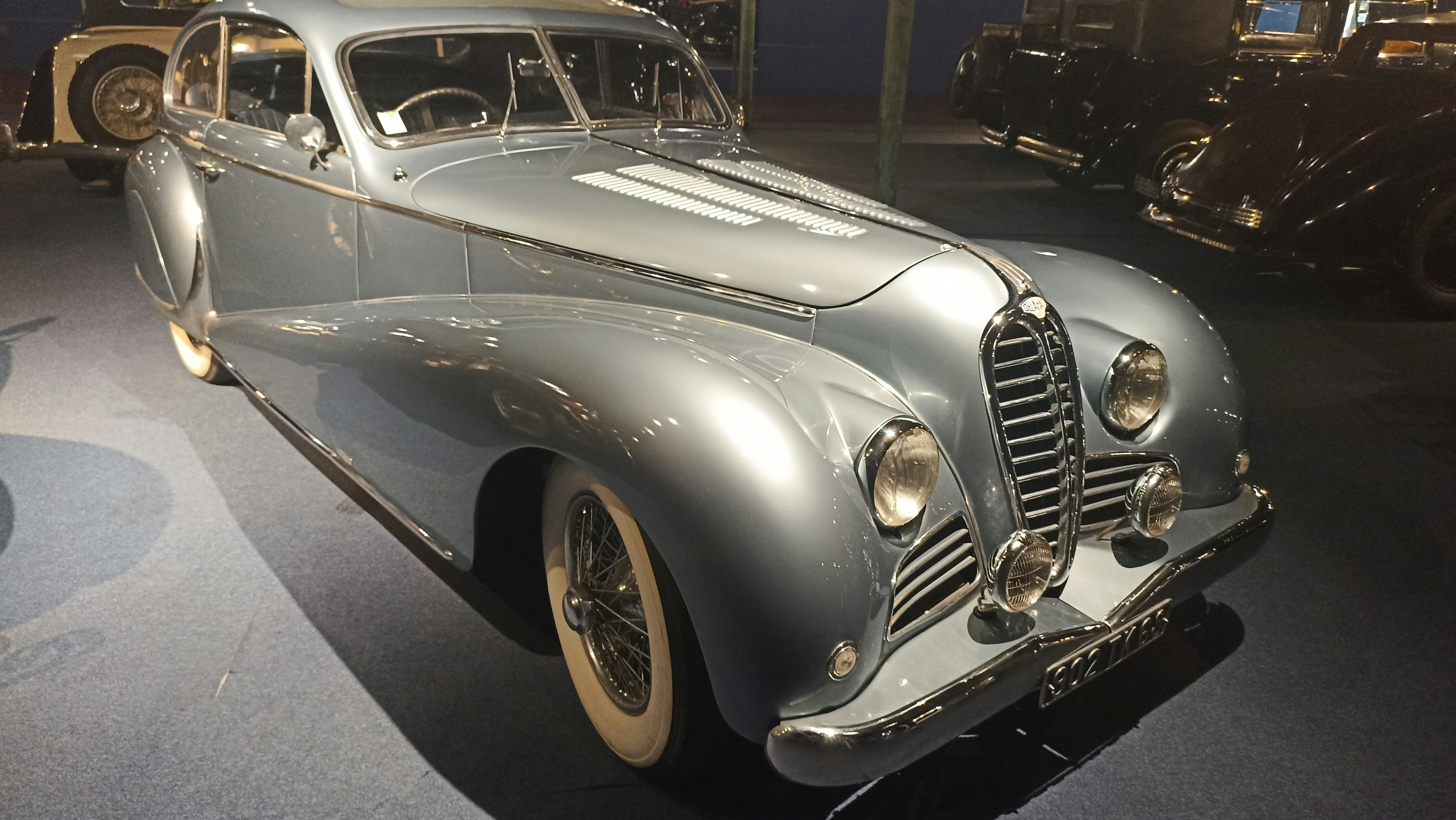 A vintage silver luxury car on display