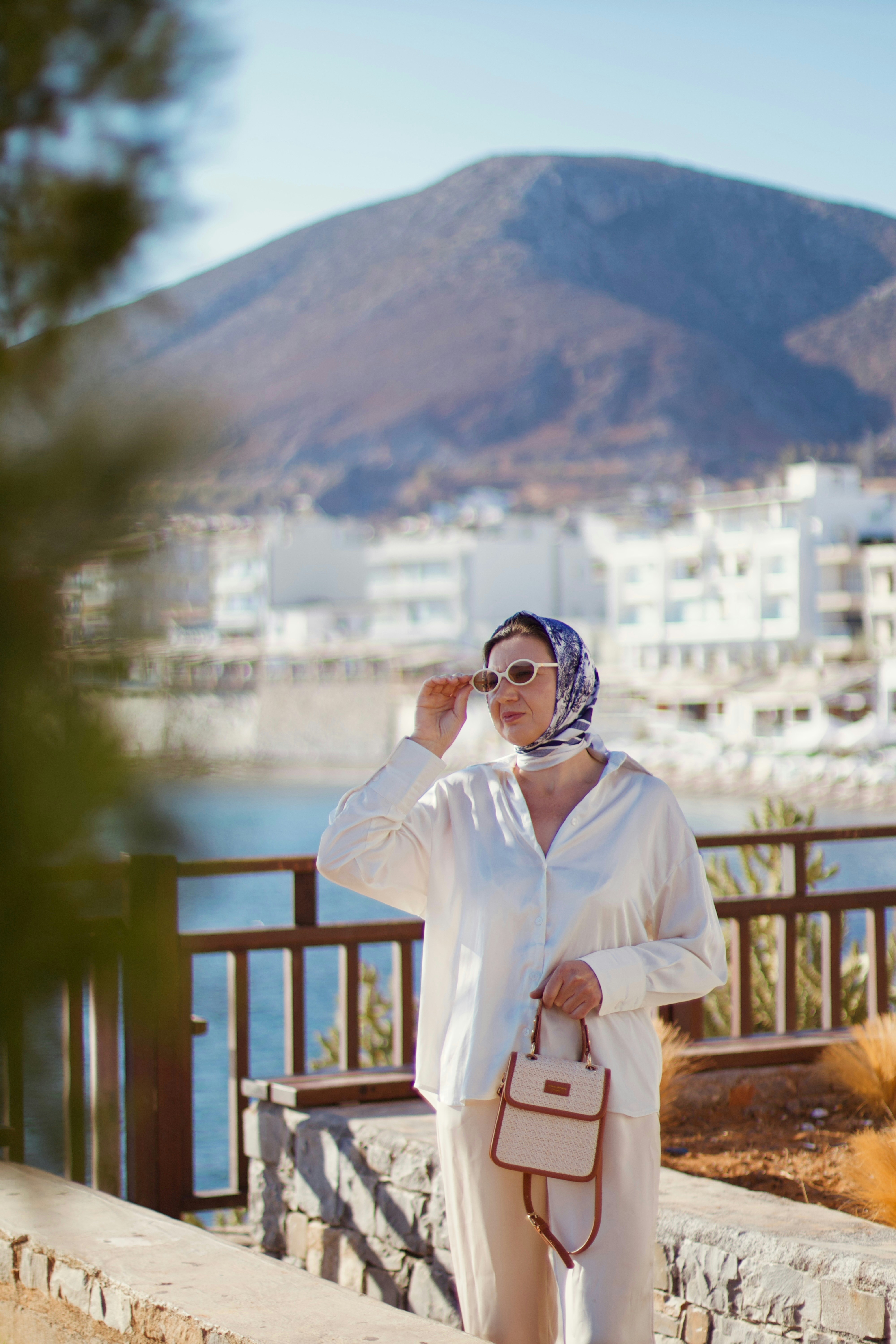 Woman in sunglasses and headscarf with purse