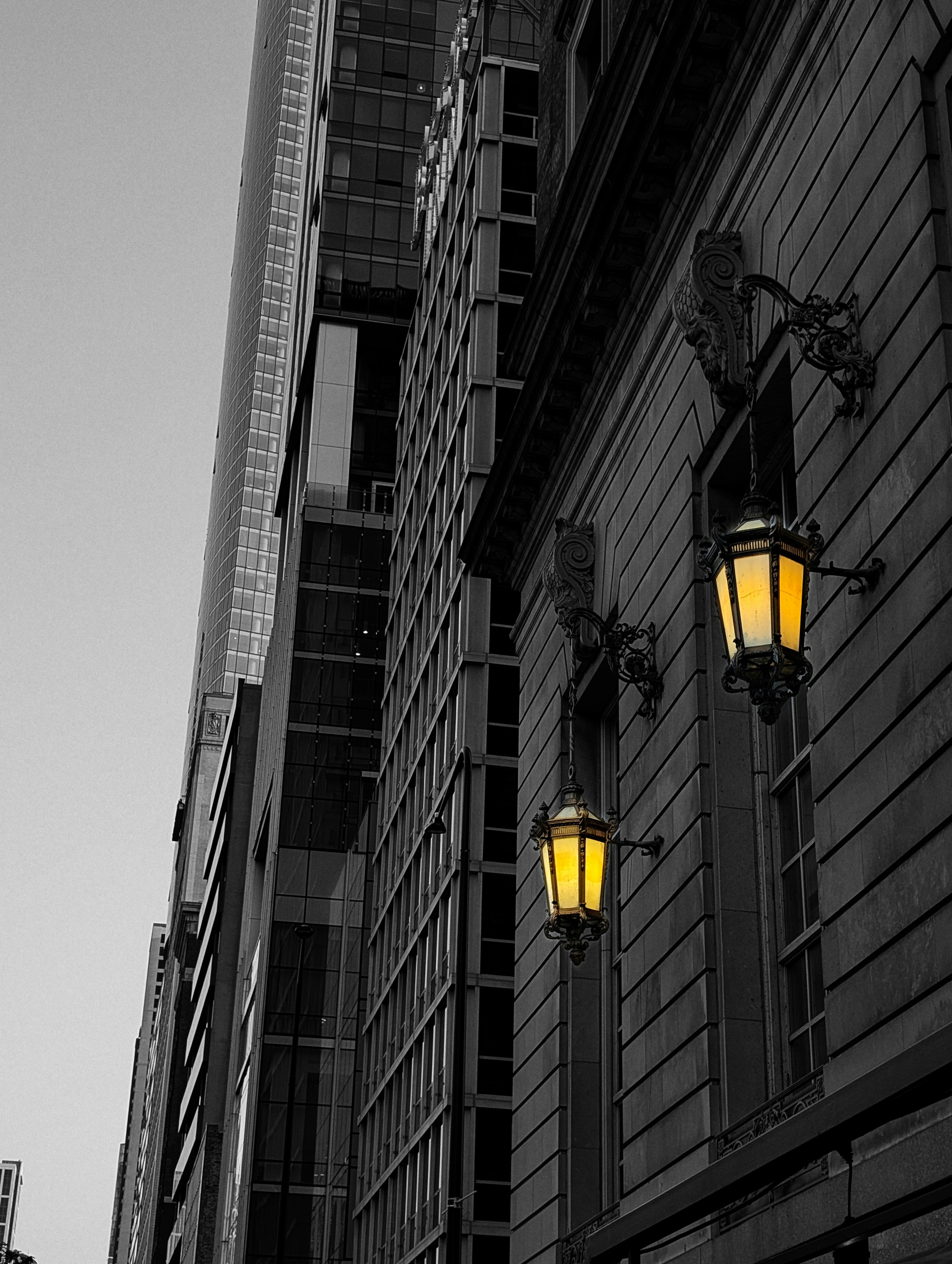 Two vintage lanterns illuminate a brick building.