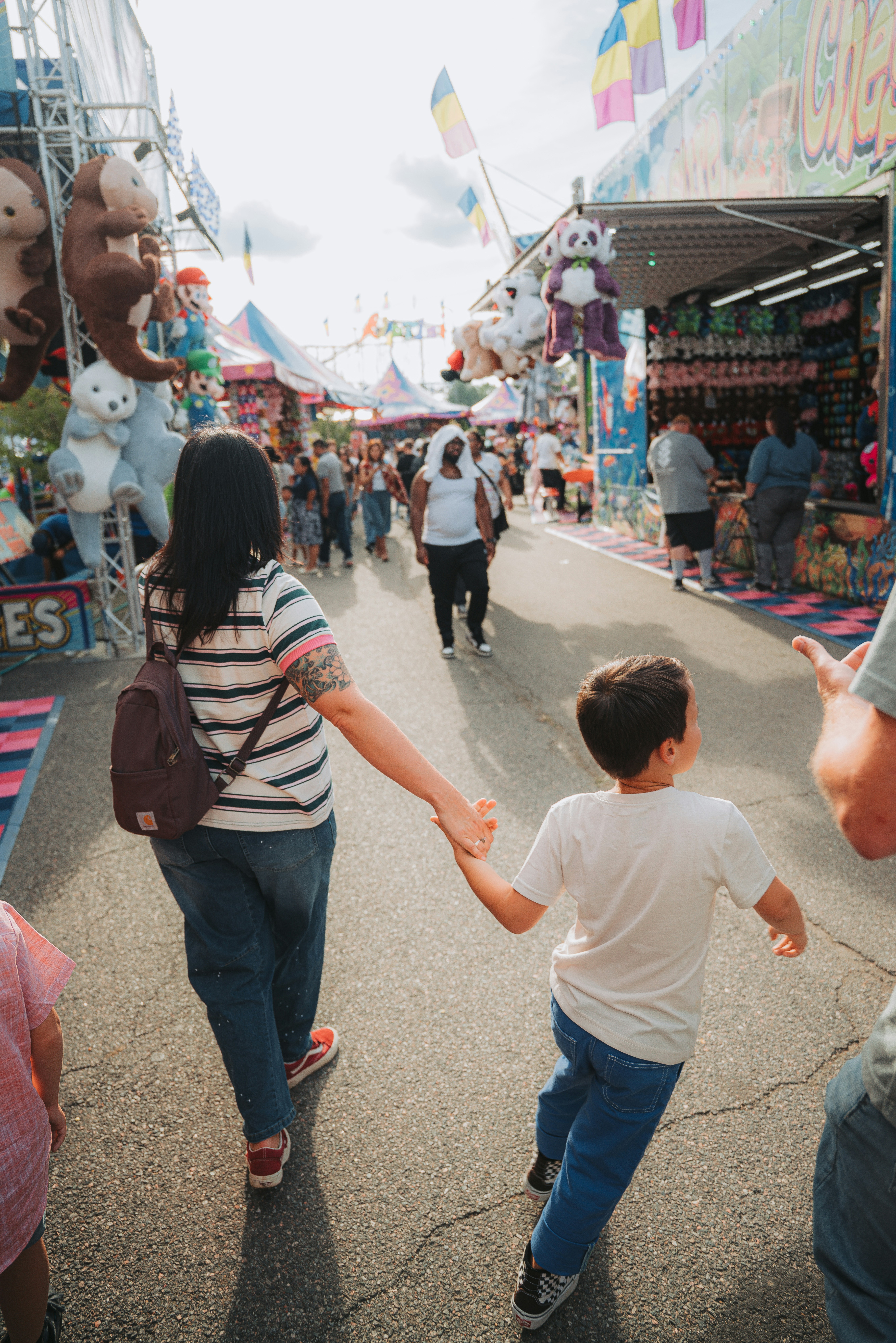 Family walking through a busy carnival midway.