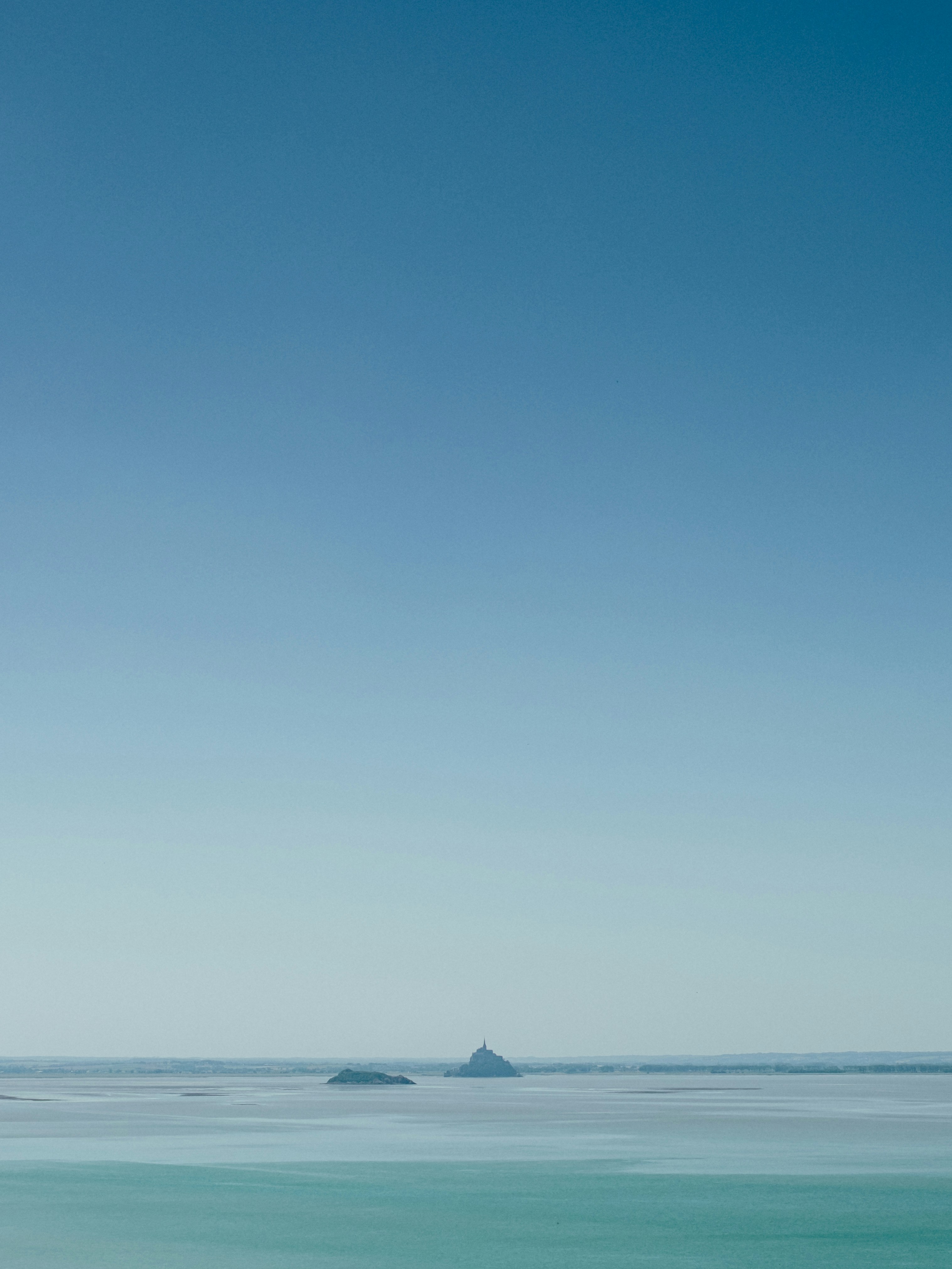 Islands on the horizon under a clear blue sky.