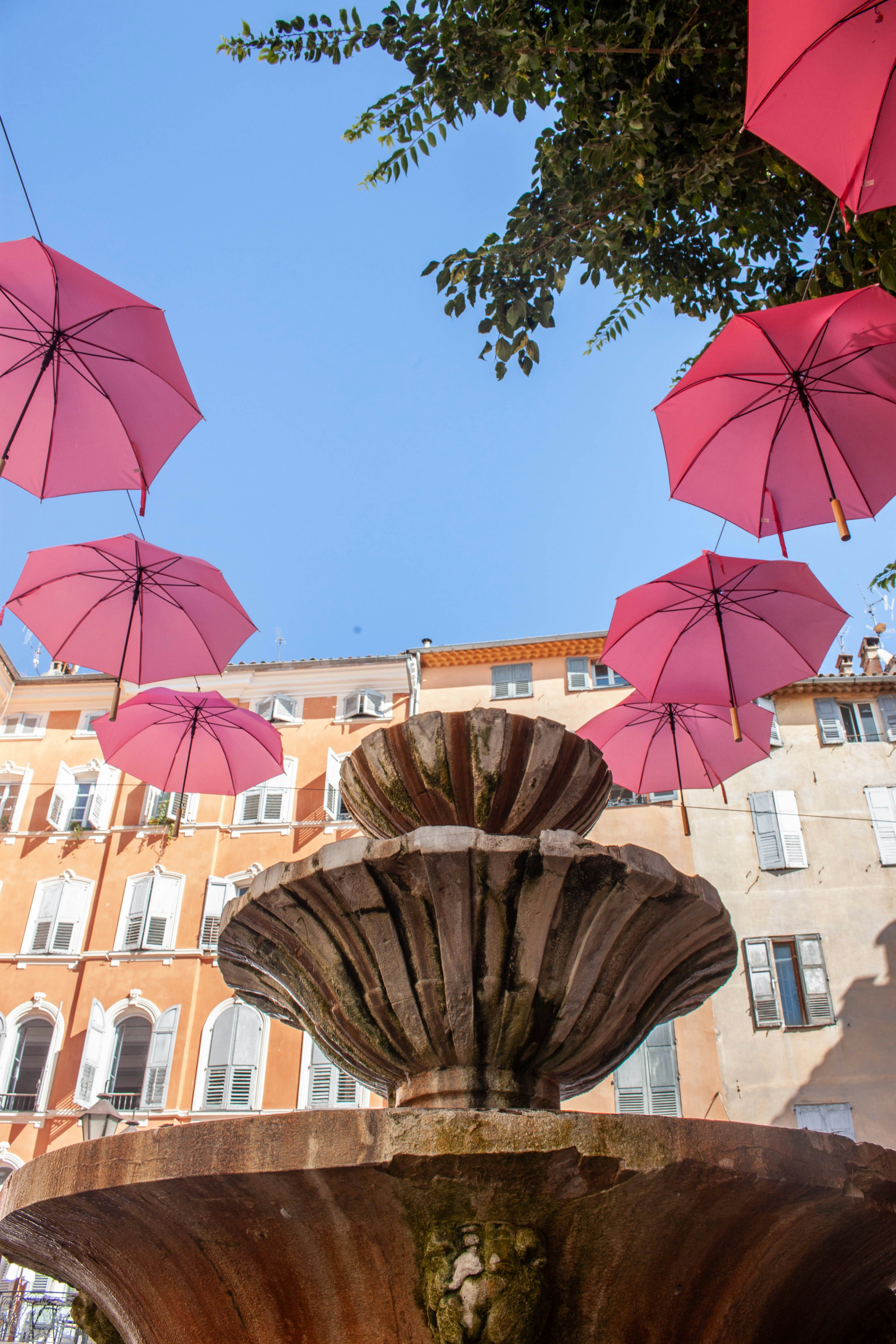 Whimsical Umbrella Canopy Over Historic Fountain