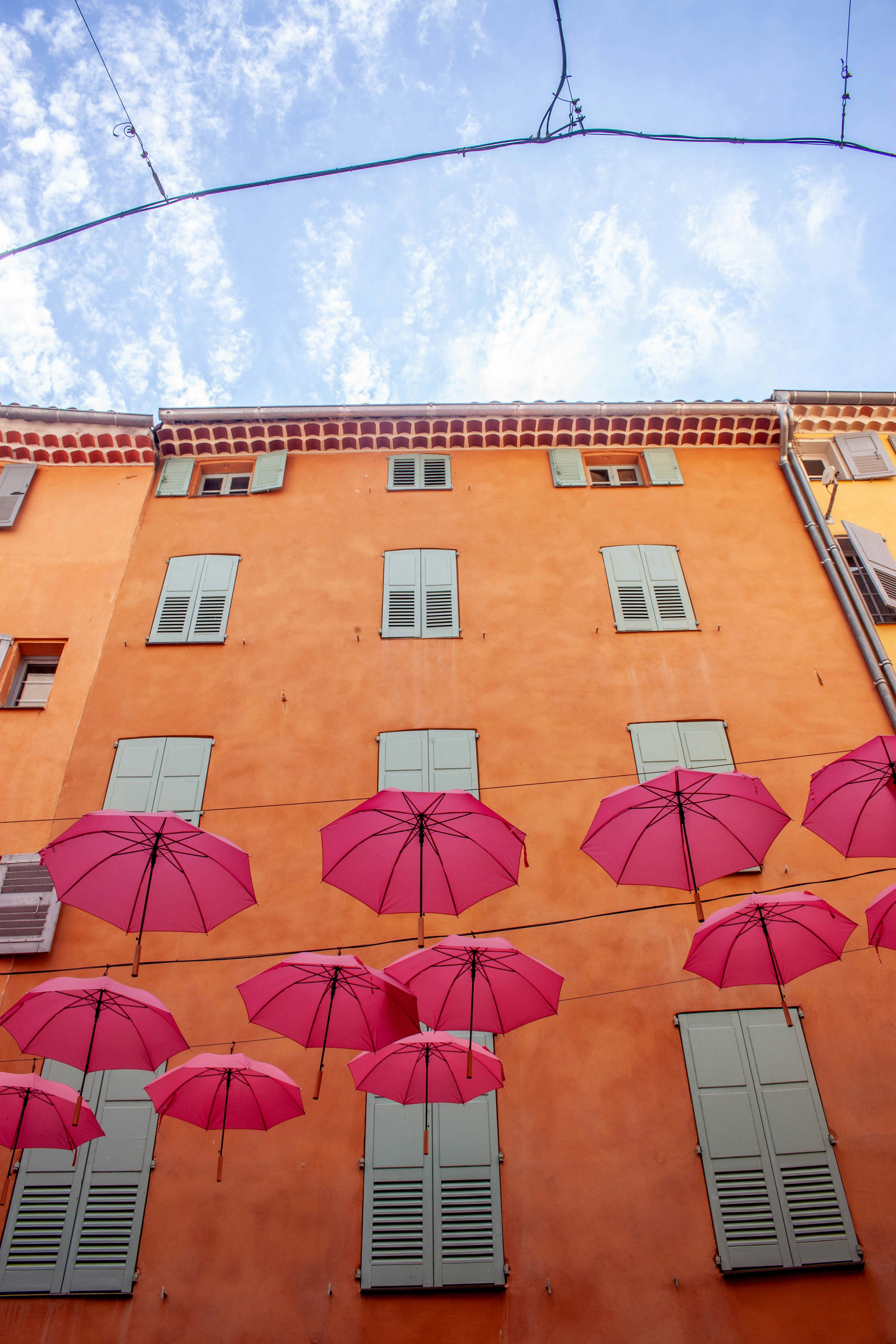 Orange Facade with Pink Umbrellas in a Mediterranean Street