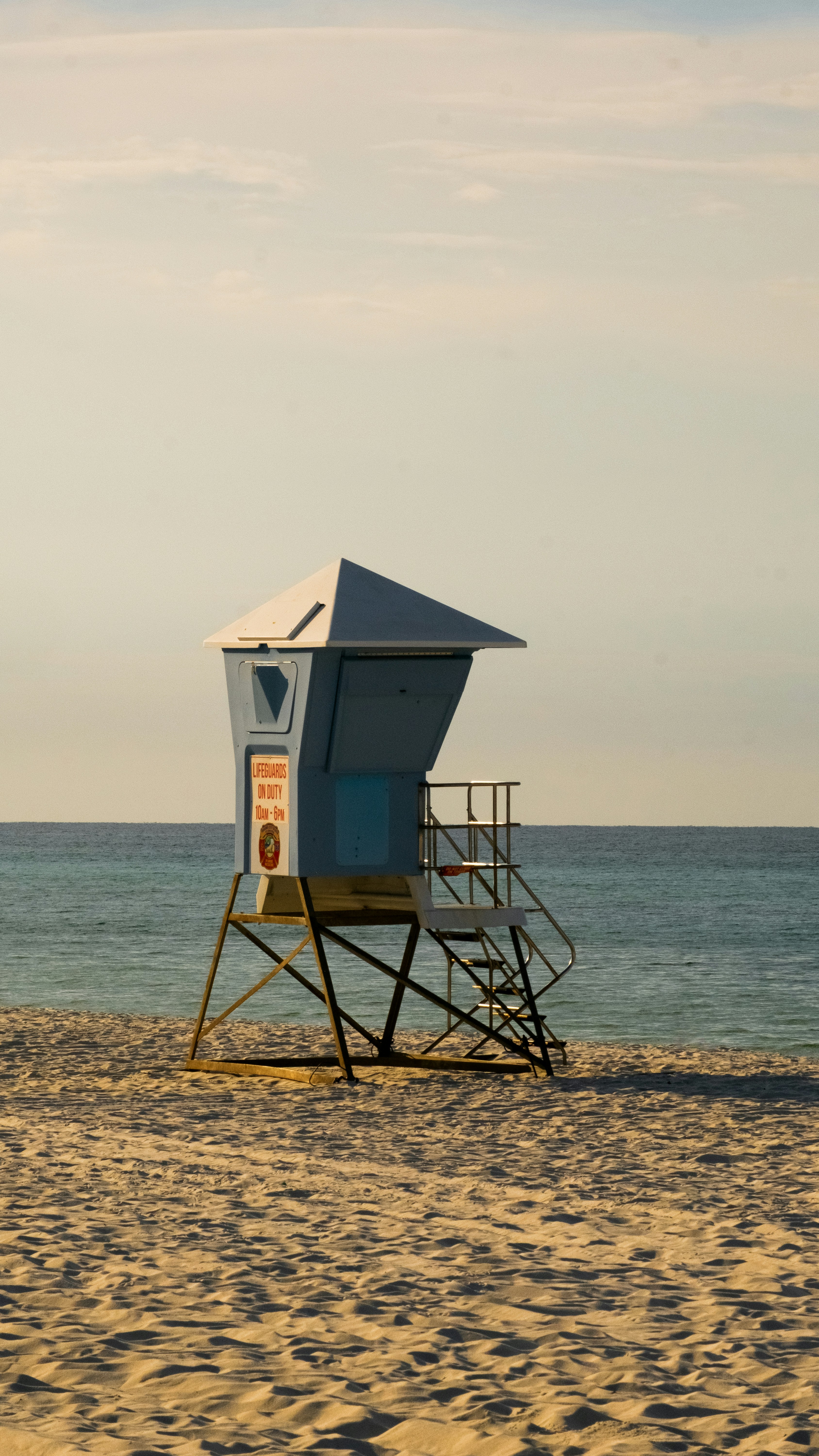 A blue lifeguard tower on a sandy beach.