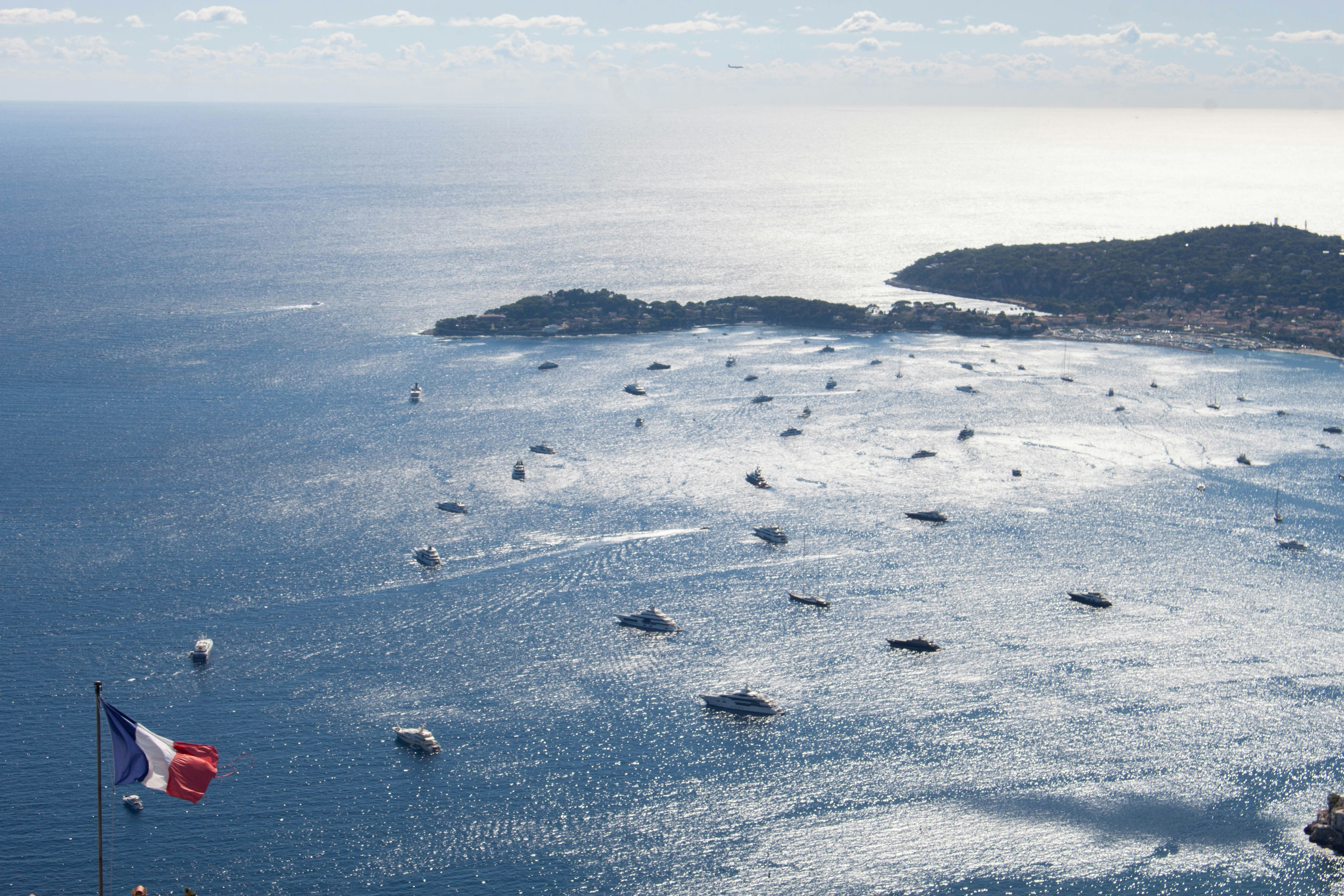 Dotted Fleet Across a Sunlit Bay Beneath a Quiet Horizon