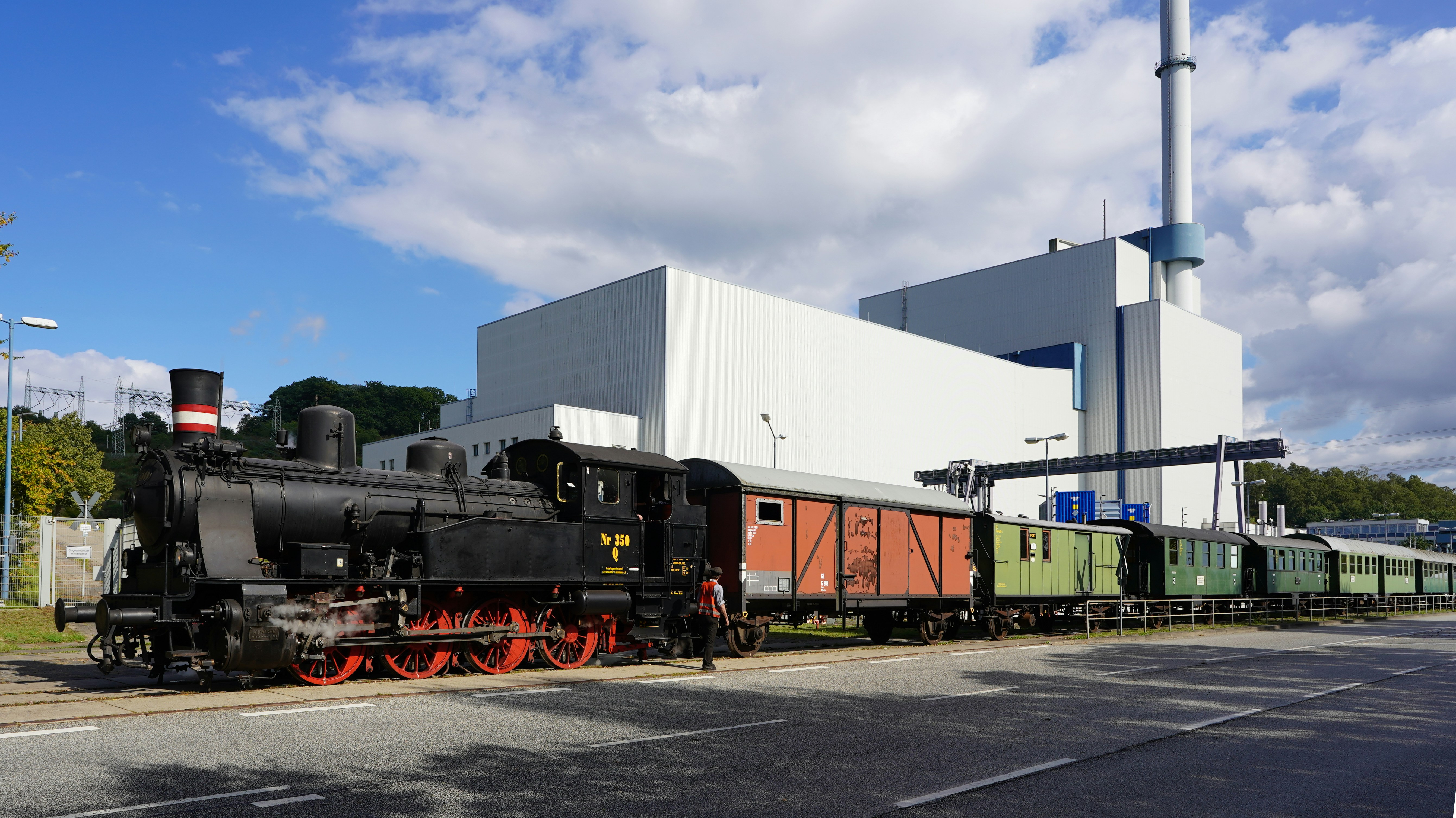 Iron Red Prodigy: A Vintage Steam Locomotive at Rest on a Modern Platform