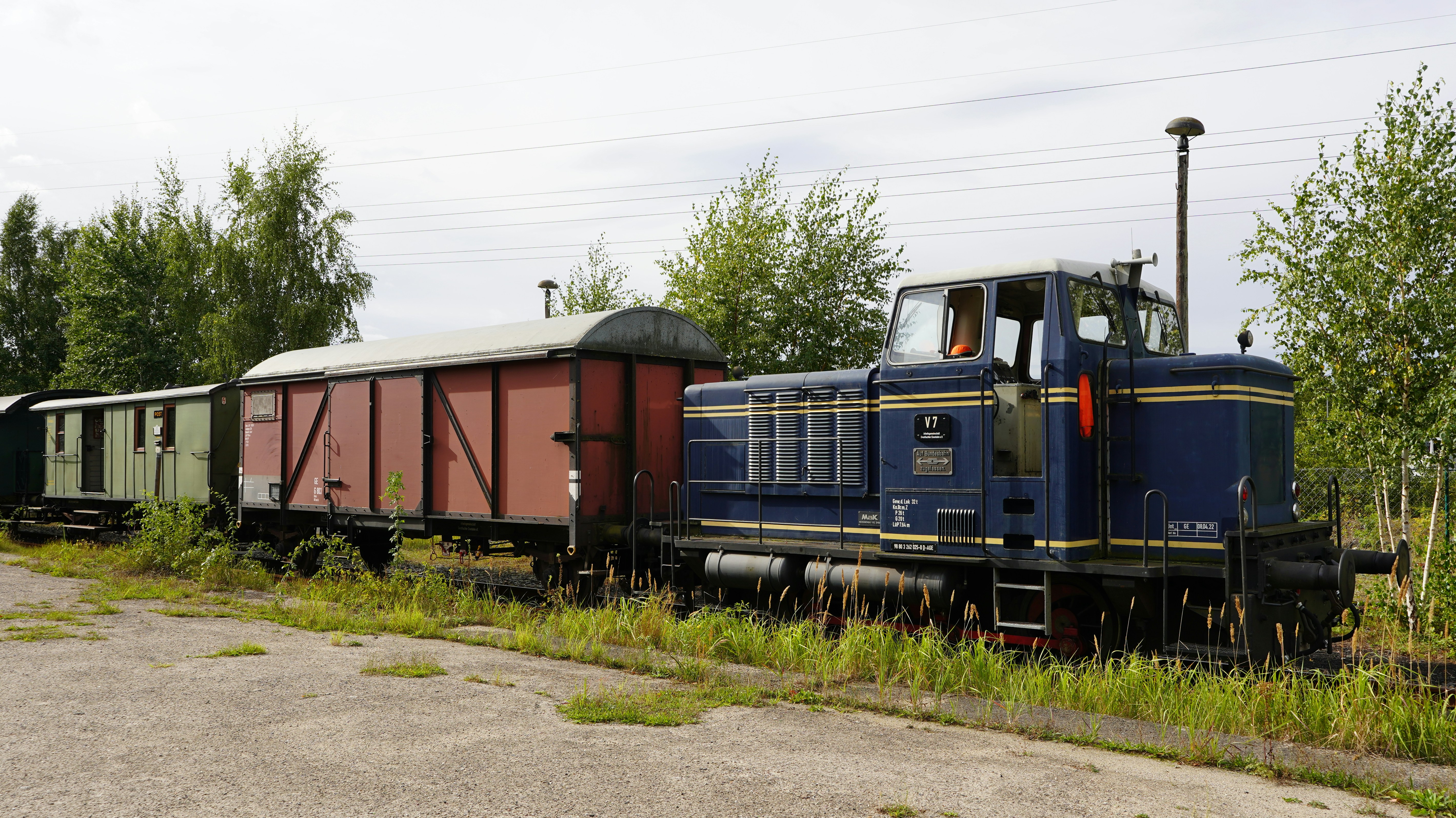 Blue diesel locomotive with two freight cars