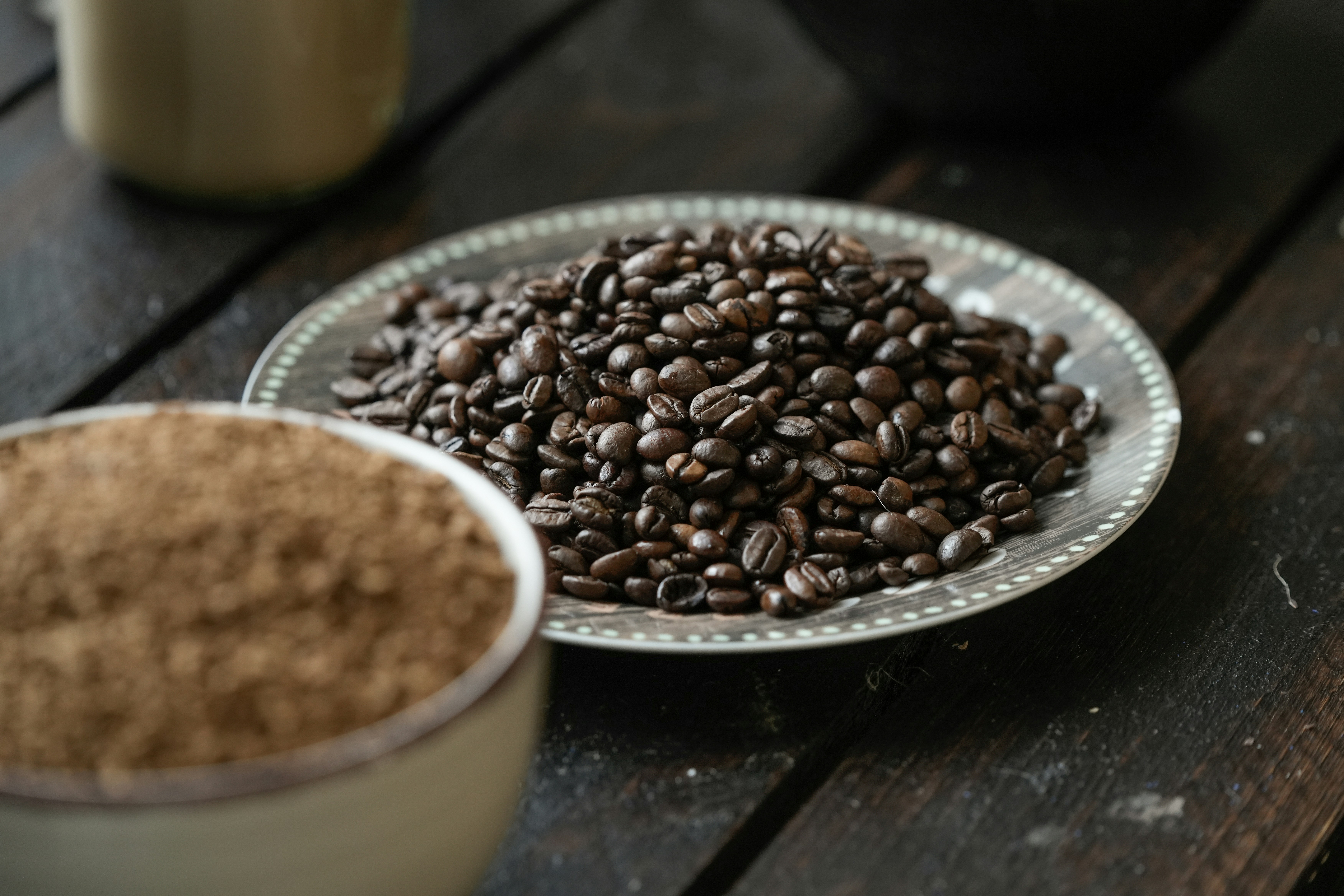 Pile of roasted coffee beans on a metal plate.