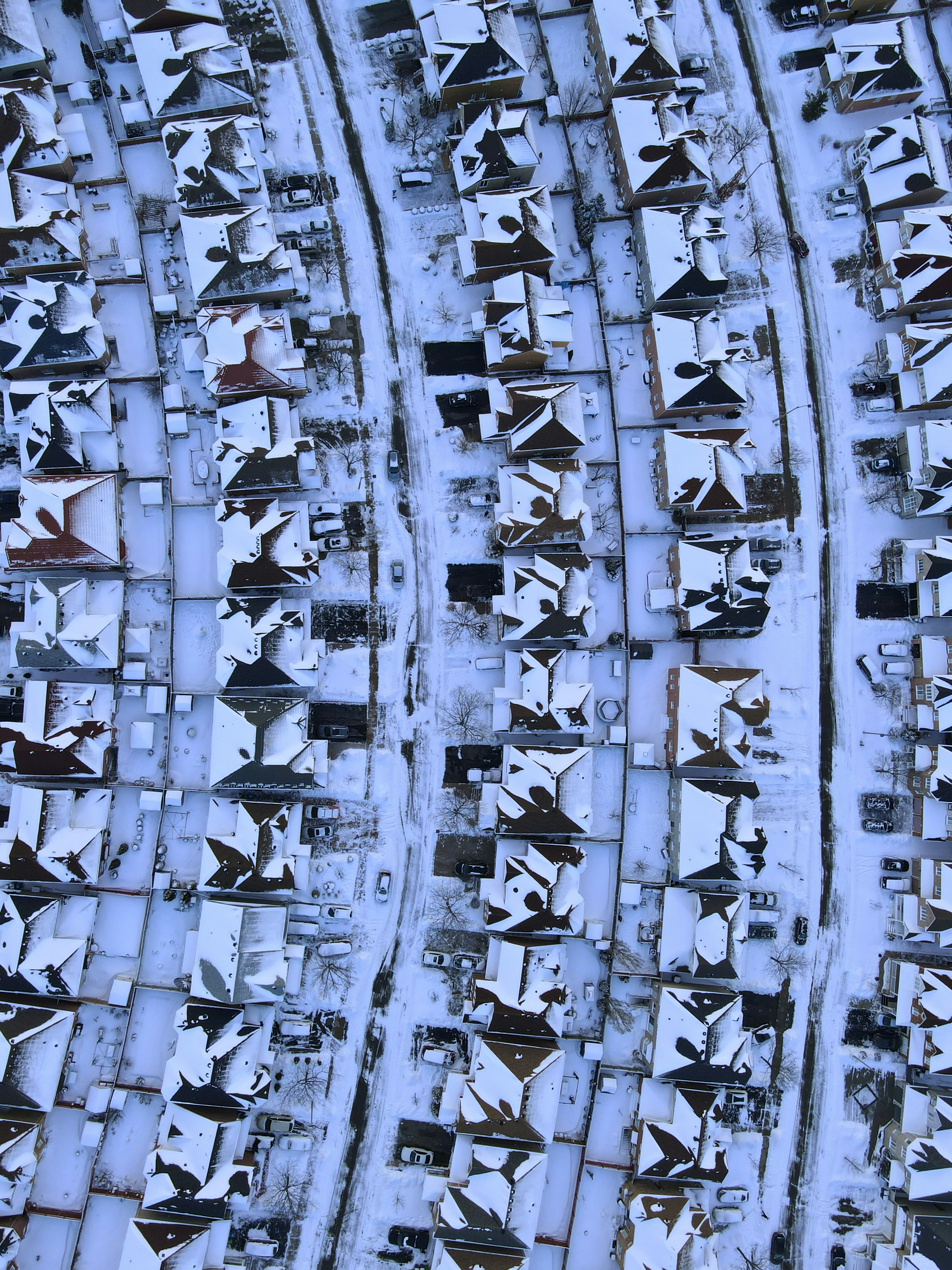 Aerial view of snow-covered houses in a neighborhood.