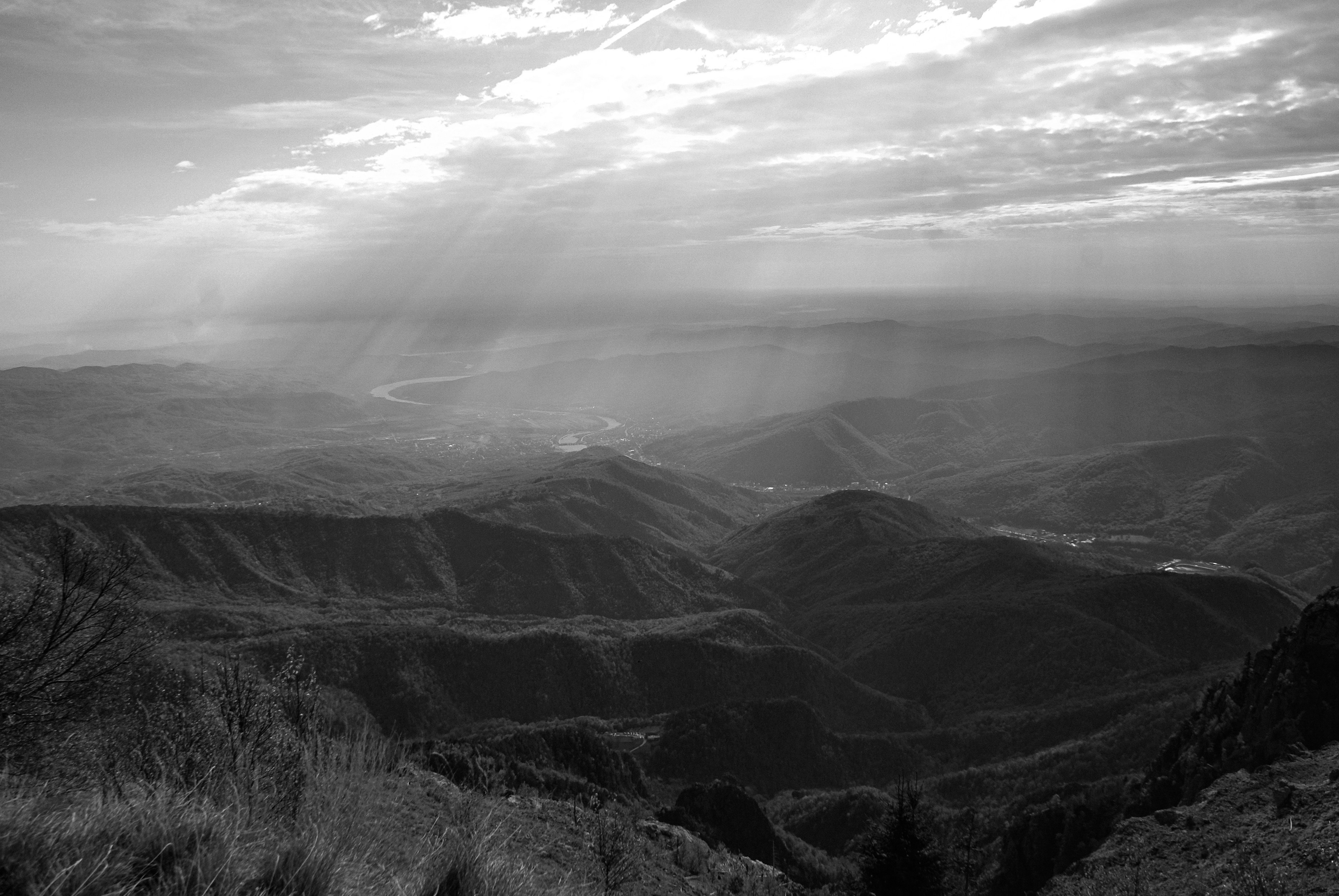 Sunbeams over rolling mountain landscape at sunrise