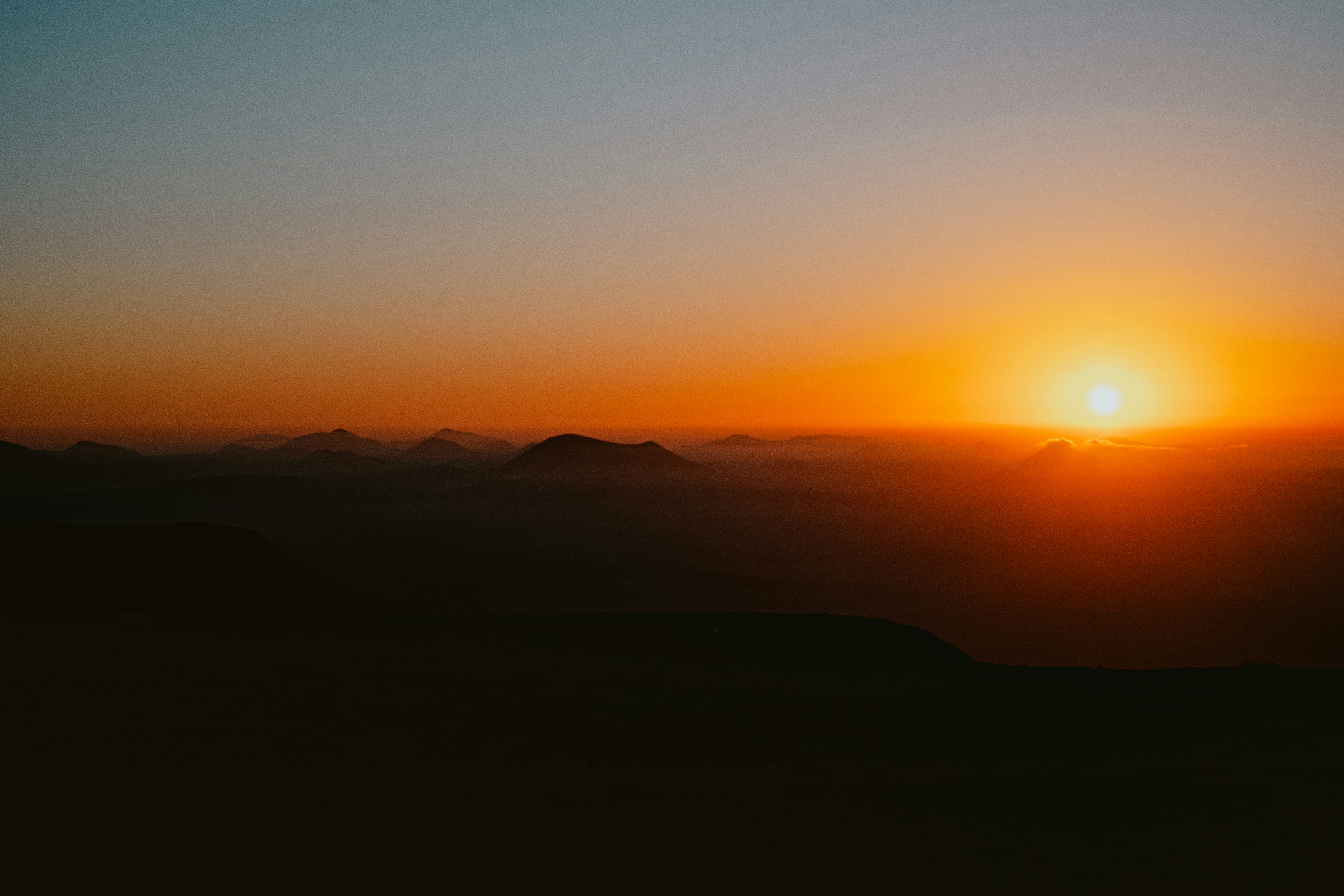 Sunrise over mountains with clouds below