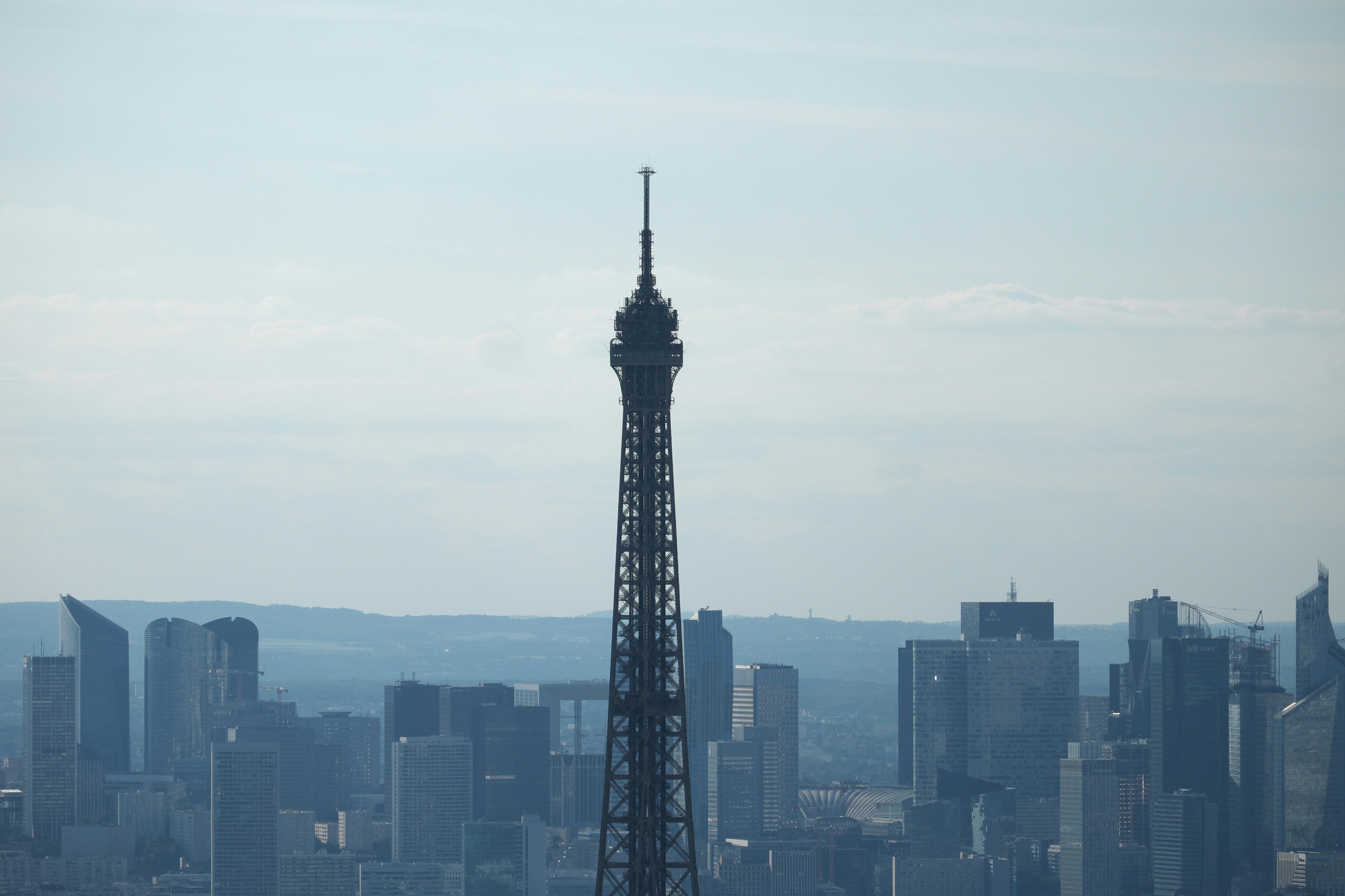 Eiffel tower against a hazy cityscape background of buildings