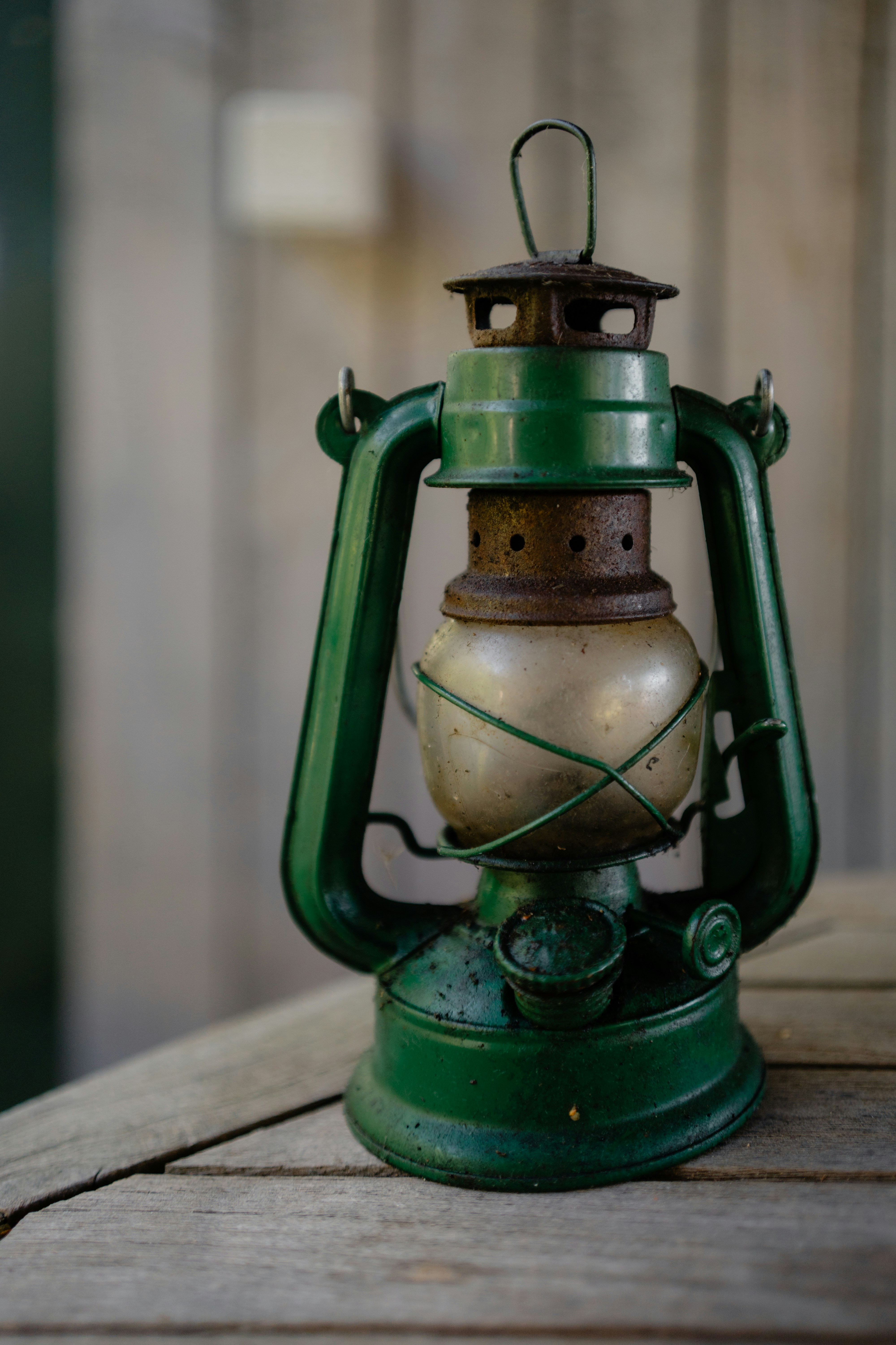 An old green kerosene lantern on a wooden table