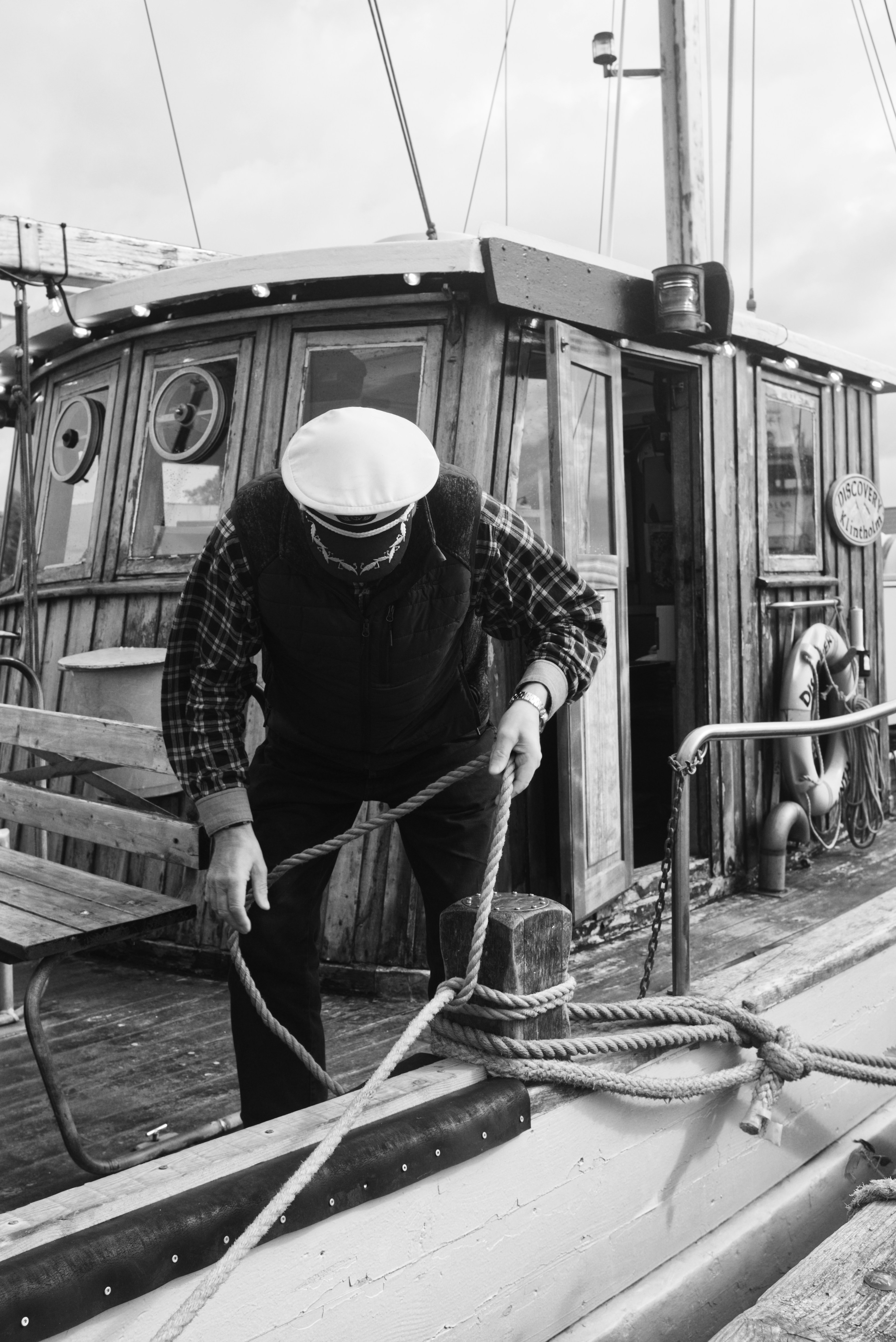 Man tying rope to boat on a dock.