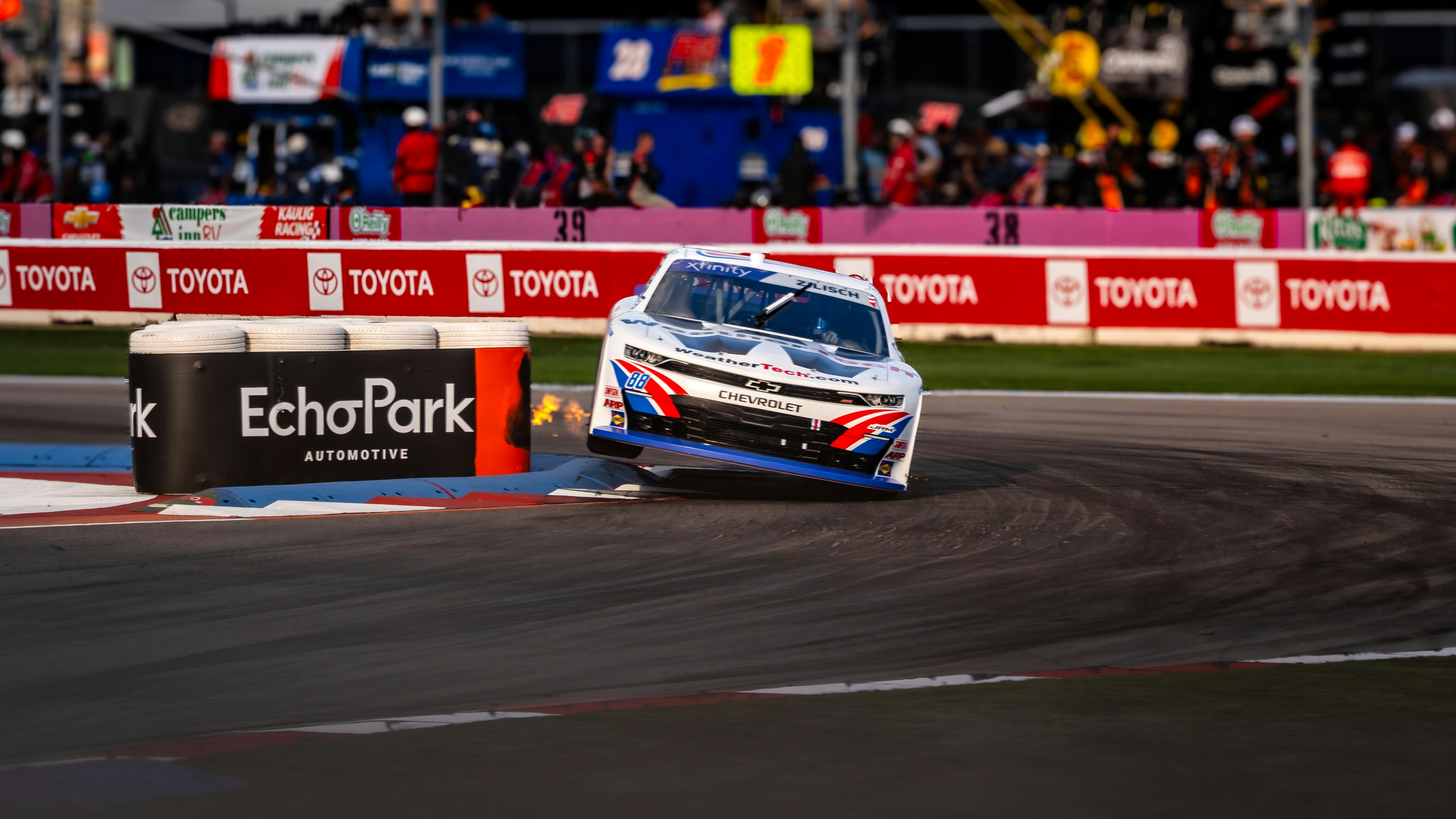 Race car navigating a sharp turn on the track, showcasing the thrill of motorsport. The scene captures the intensity of a live racing event.