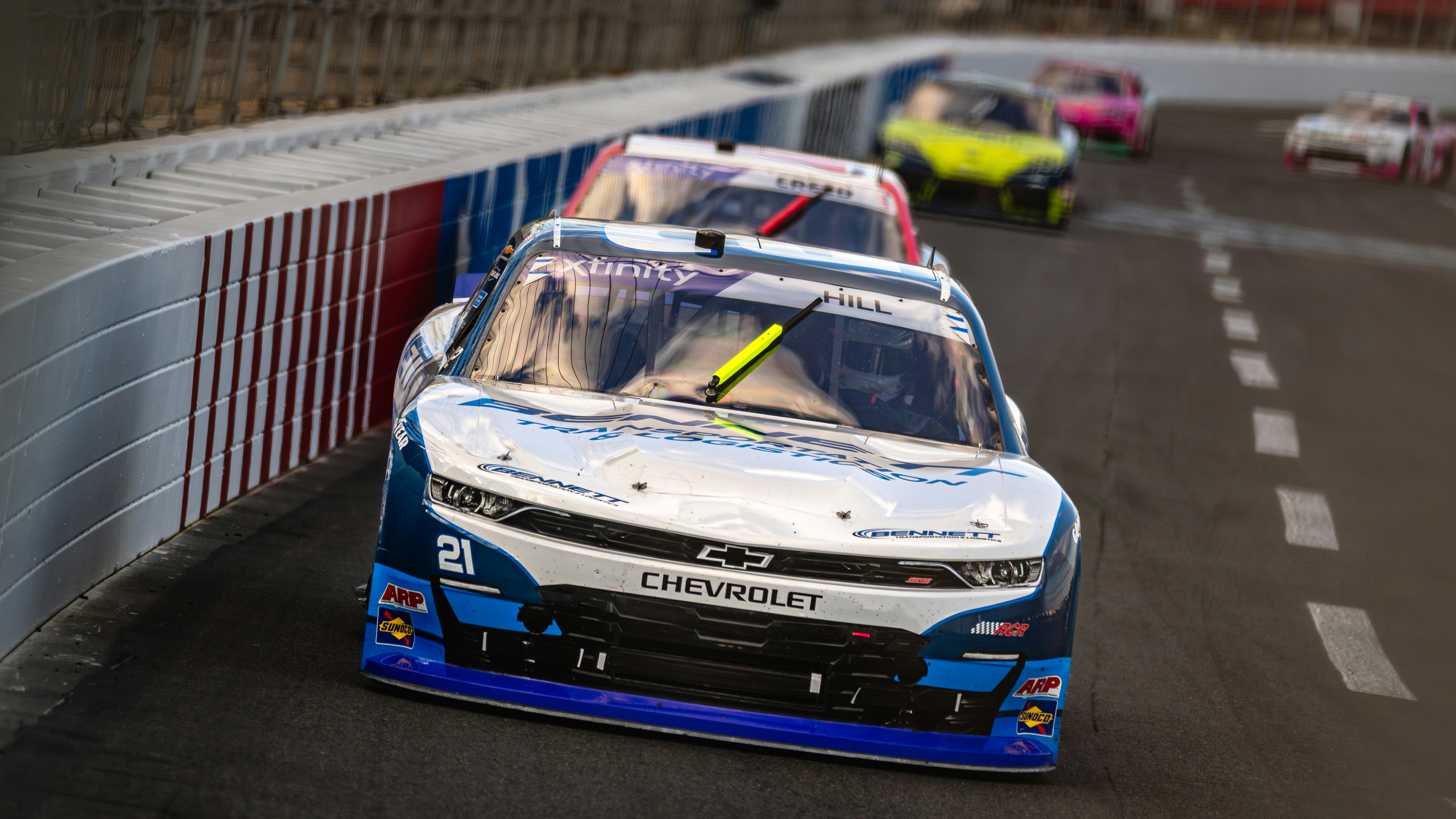 Los autos de carreras corren alrededor de una pista, cerca de la pared ...