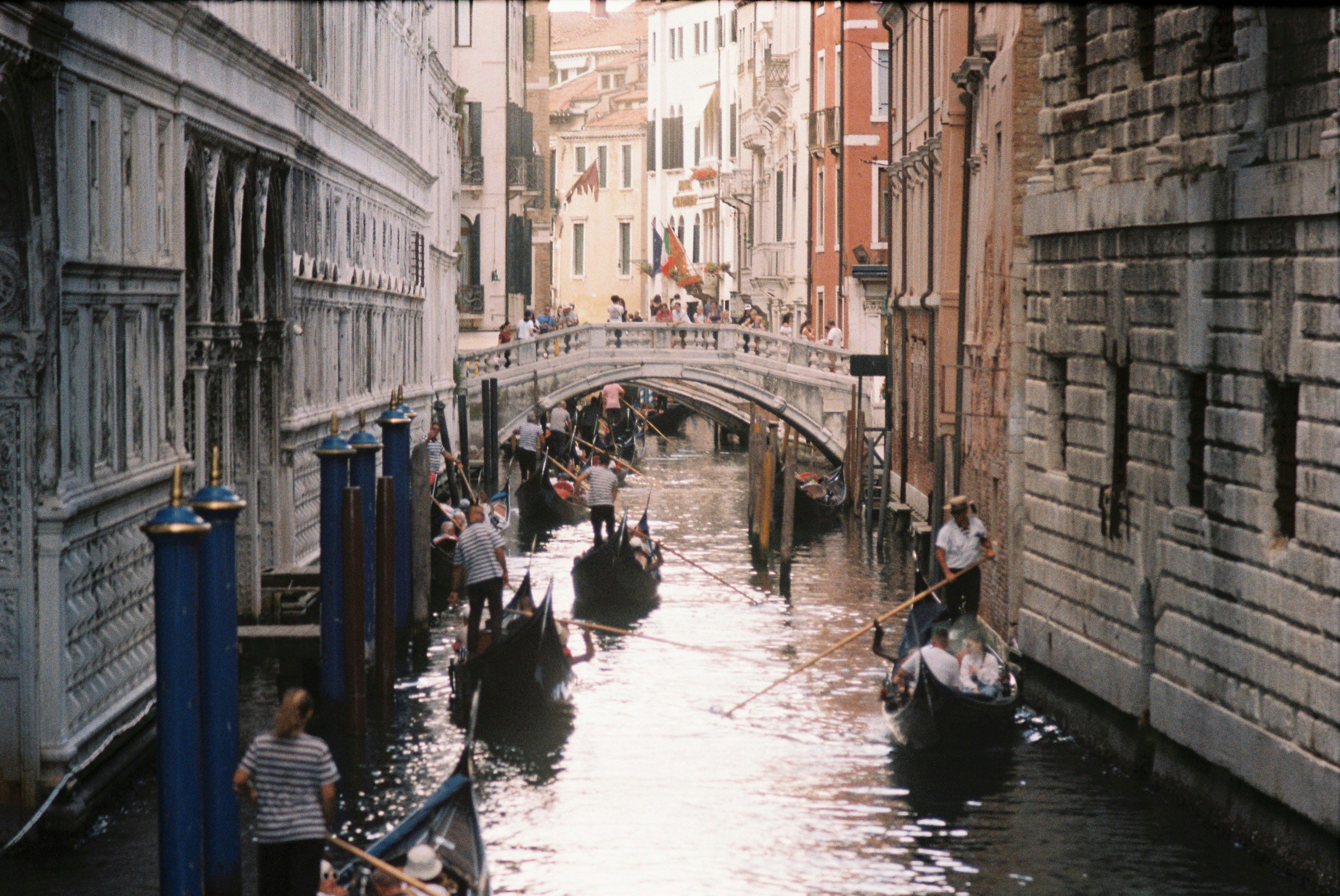 Gondolas navigate a narrow canal in venice.