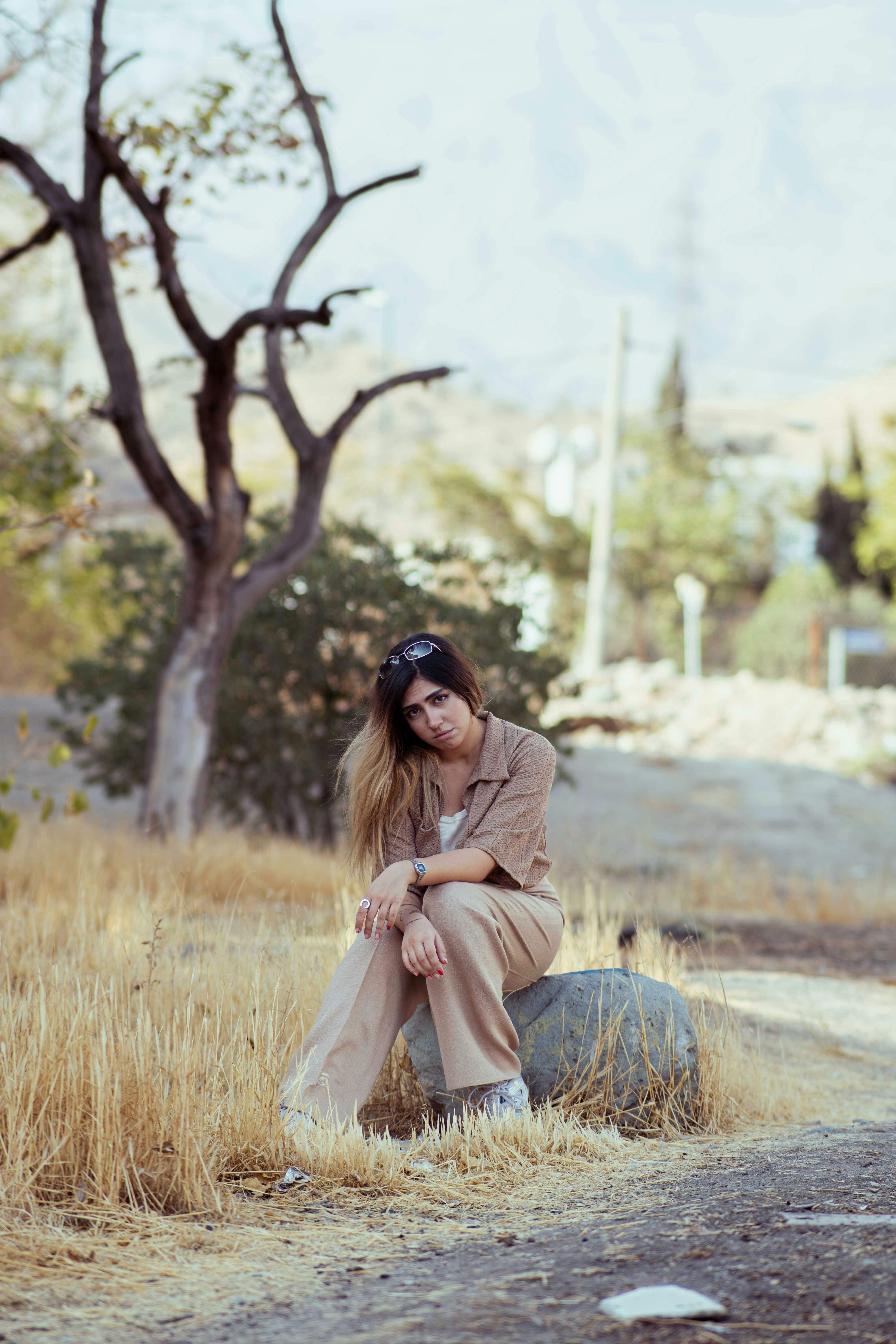 Woman sitting on a rock outdoors