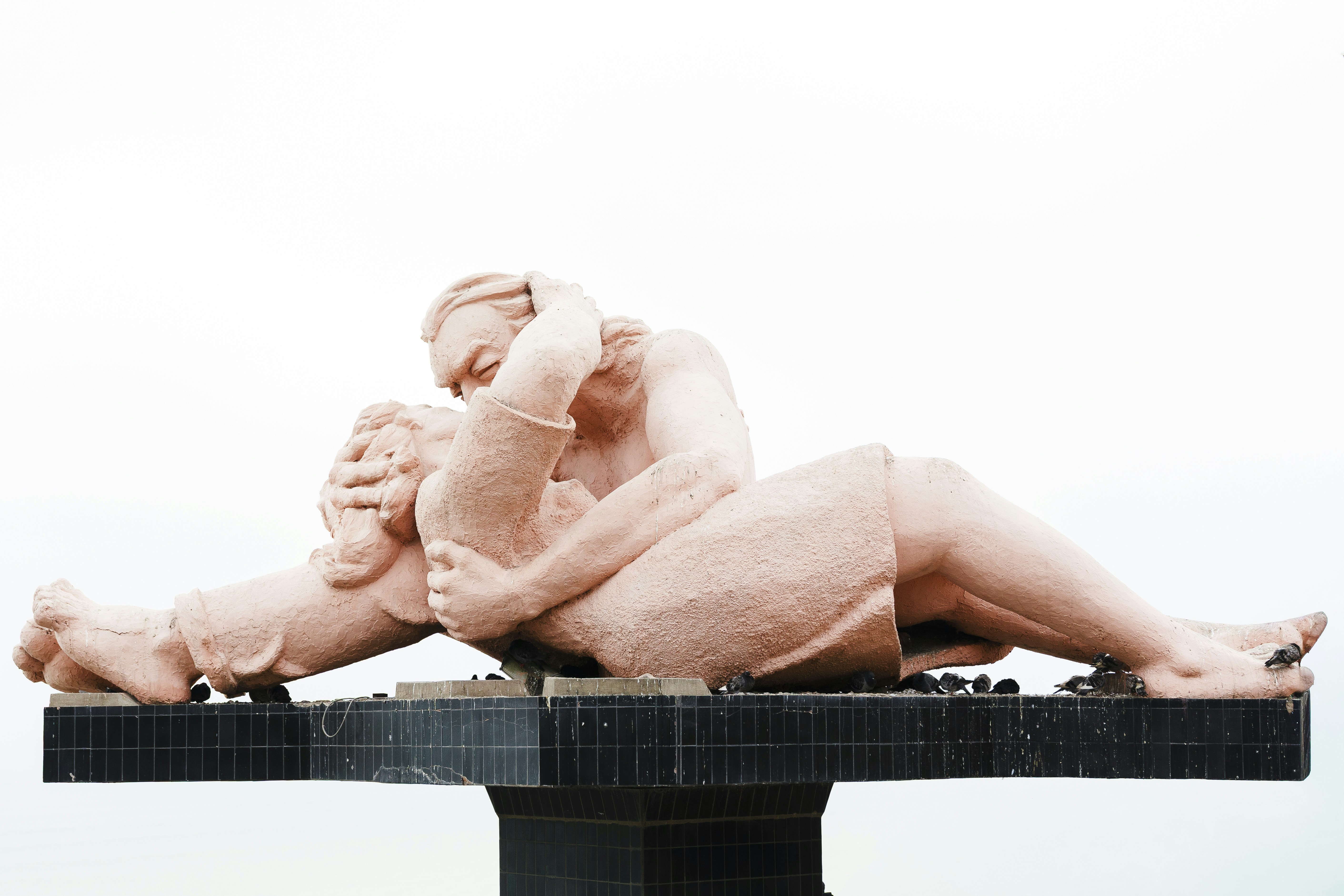 Sculpture of a couple embracing against a white background