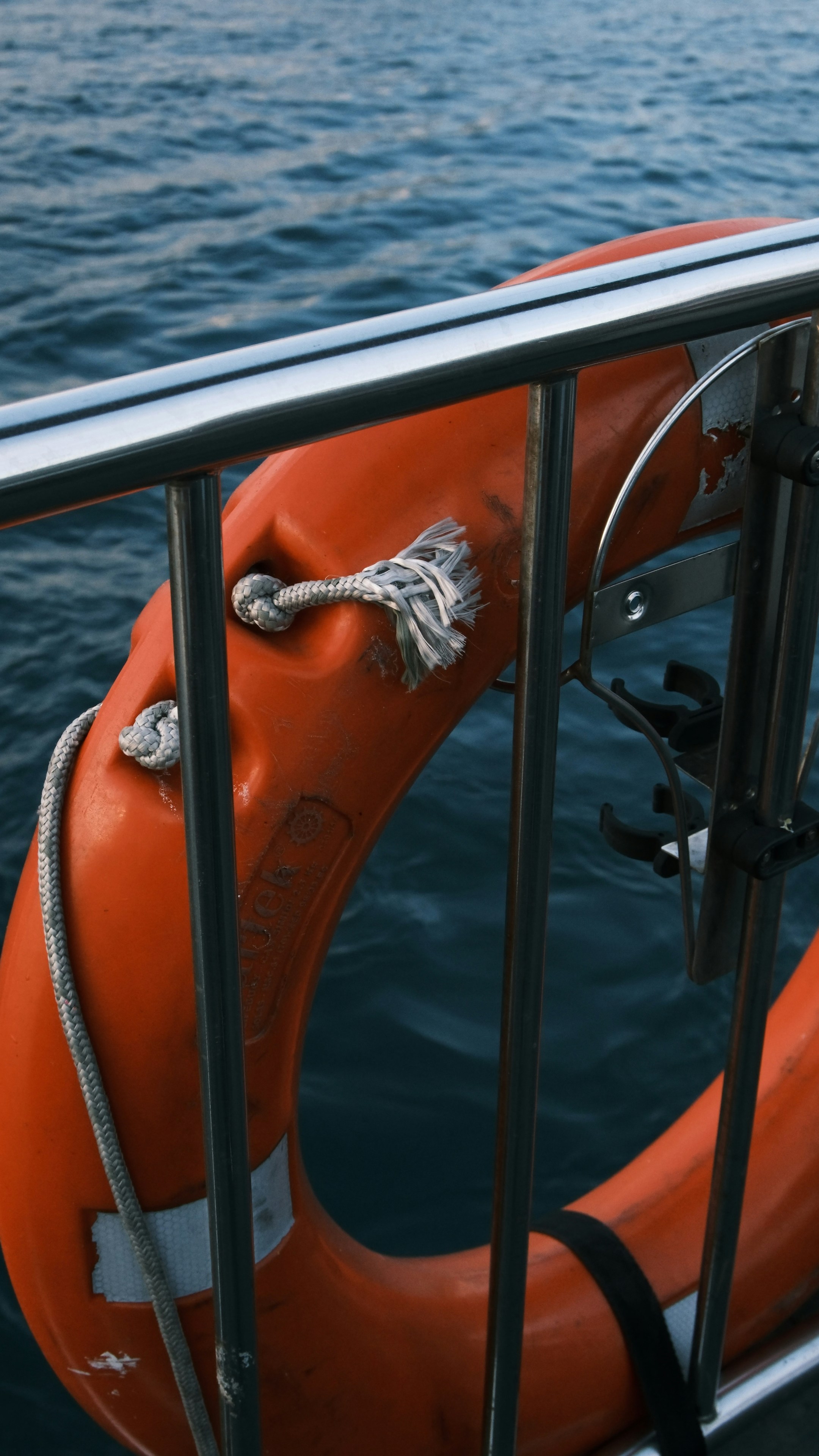 Orange life preserver attached to boat railing over water photo – Free ...