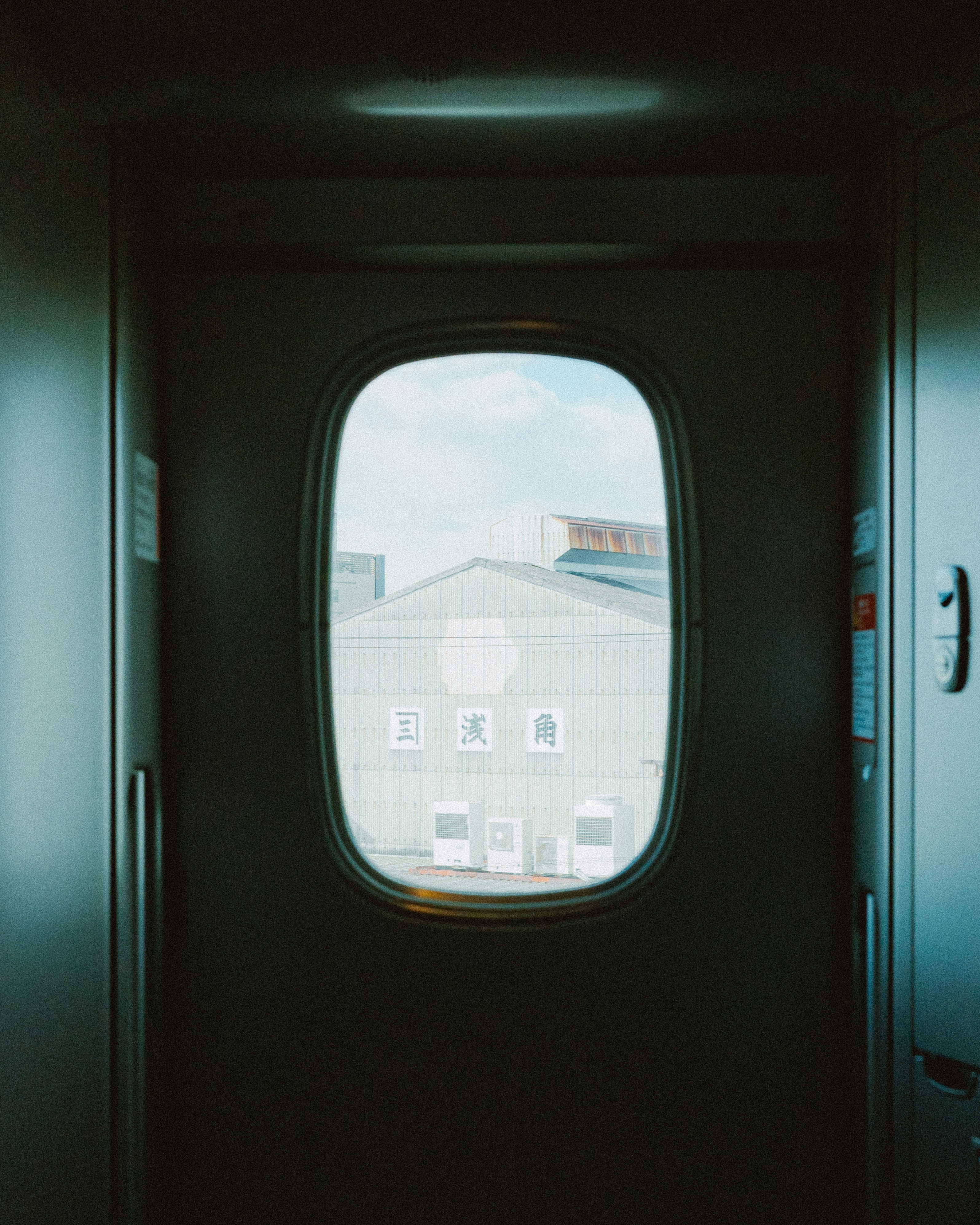 View through a train window of industrial buildings