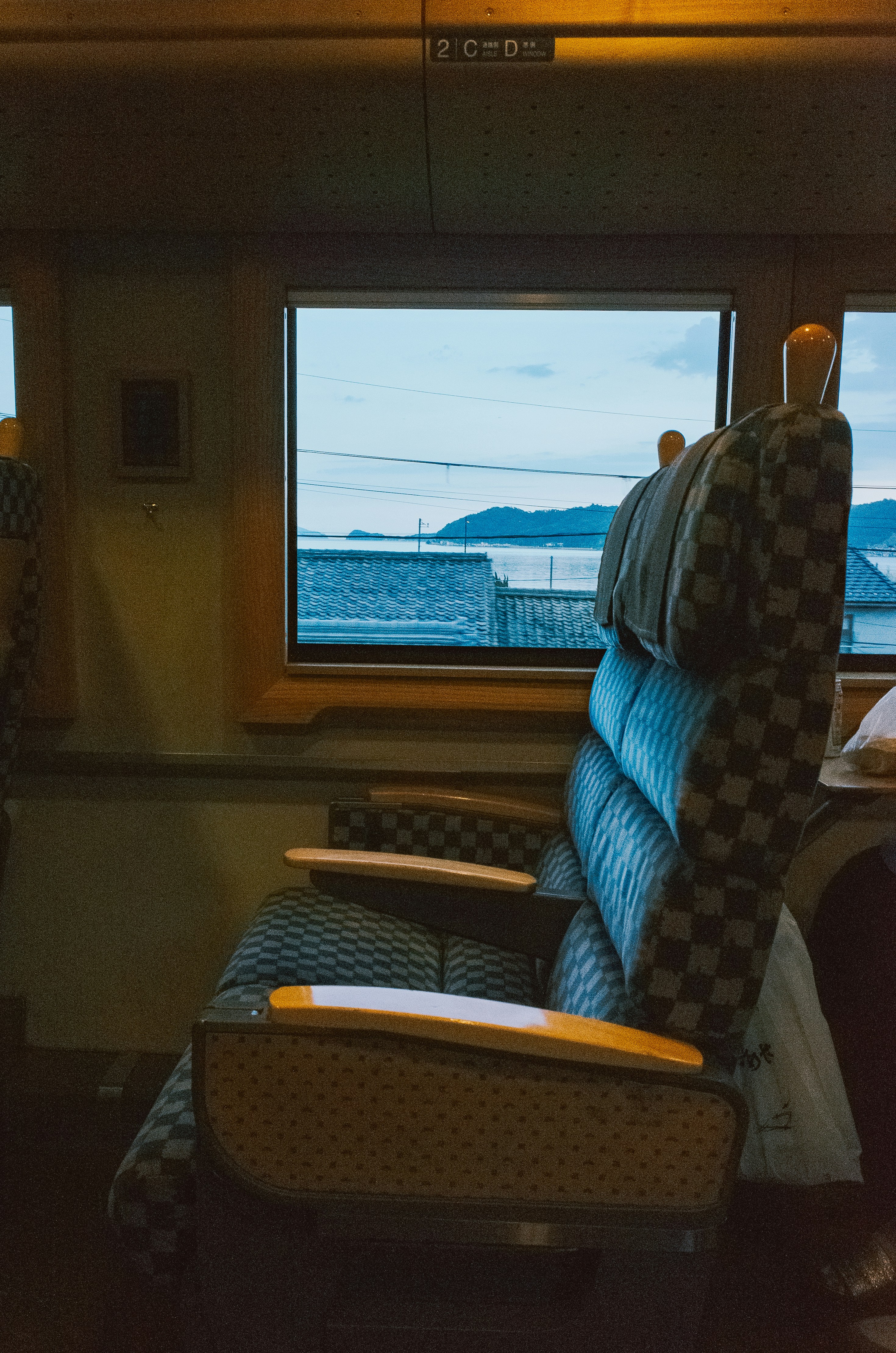 Empty train seat with view of water and land