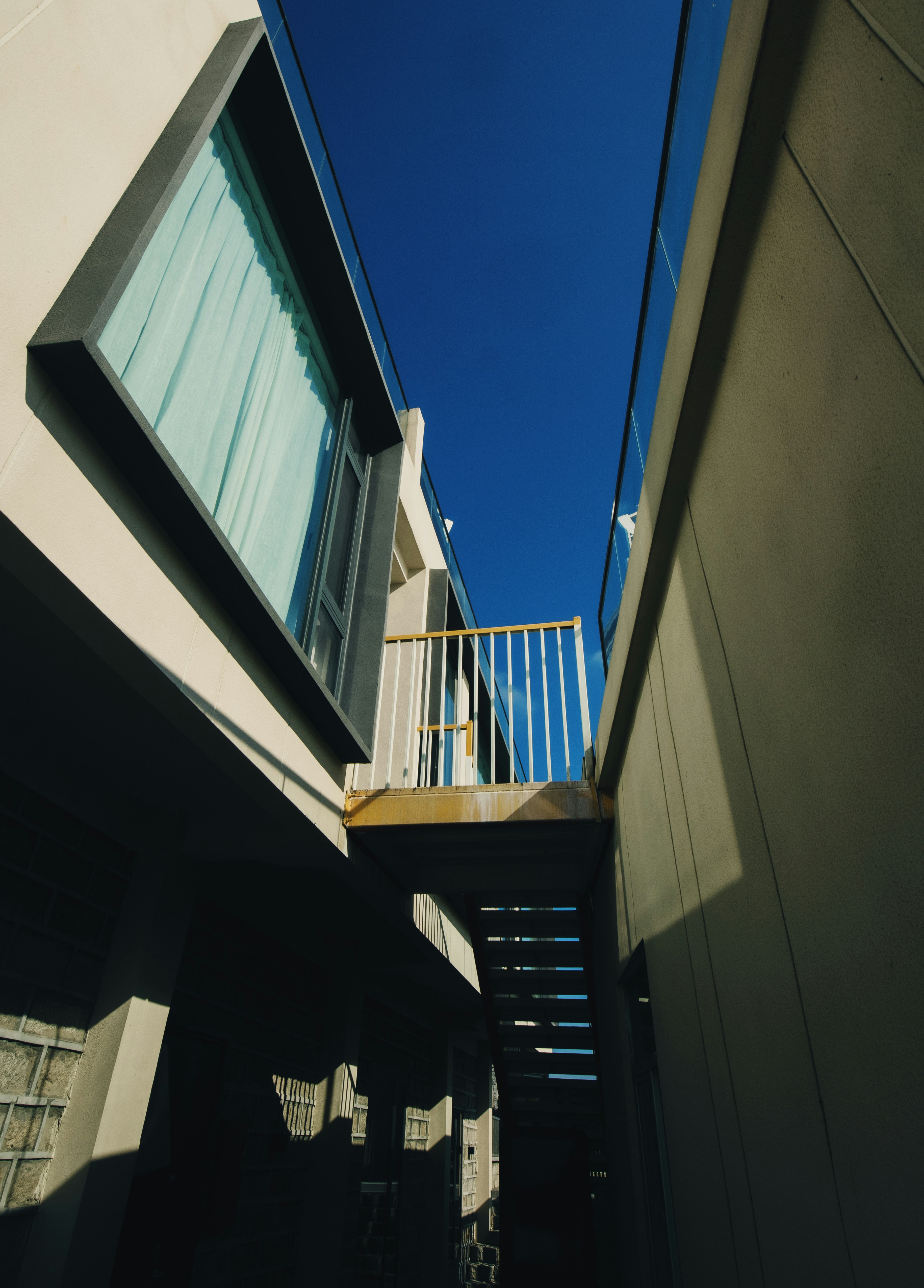 Skyward Gap: Staircase Gate Between Concrete Facades