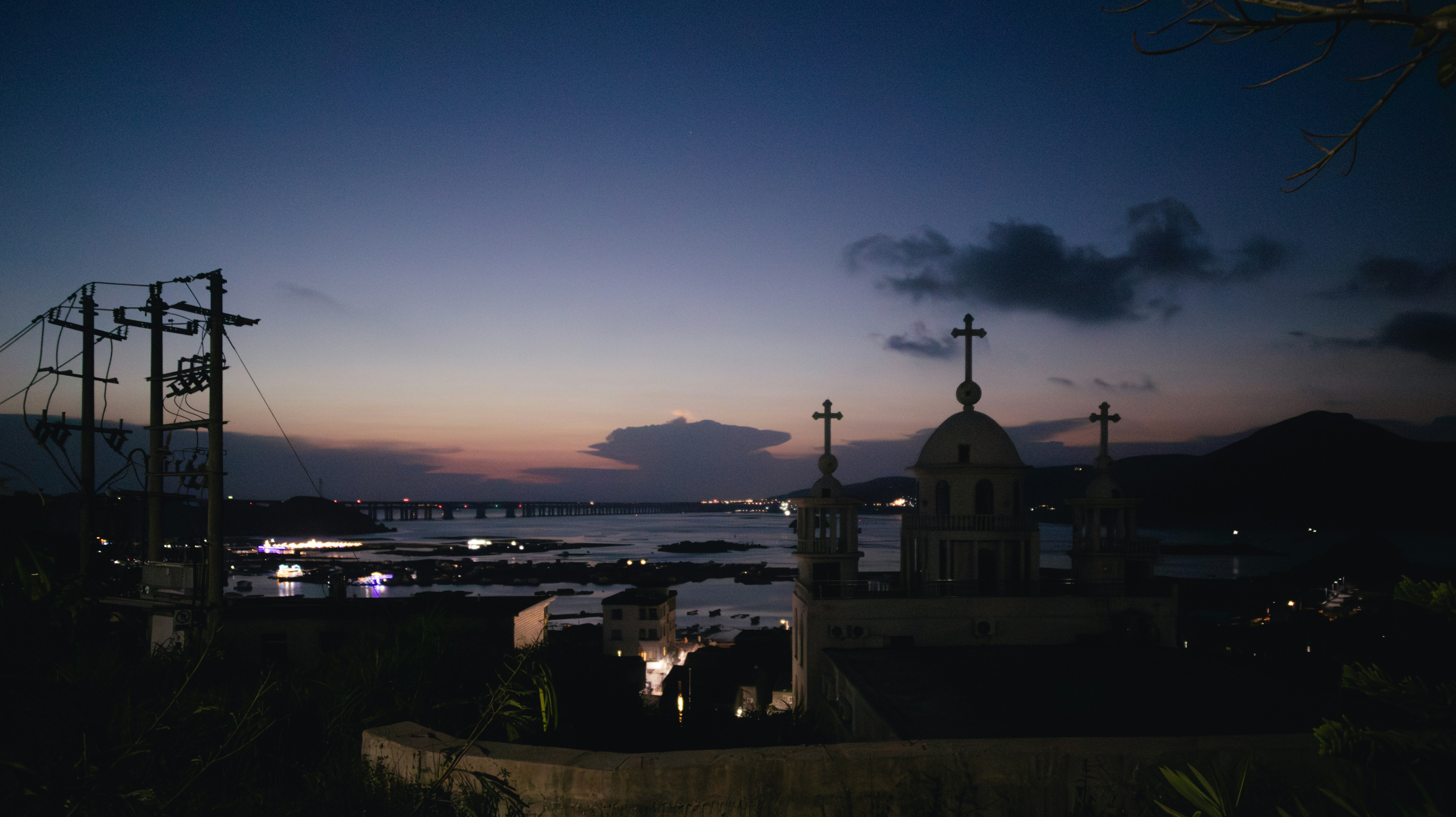 Dusk sky over a coastal town with church steeple.