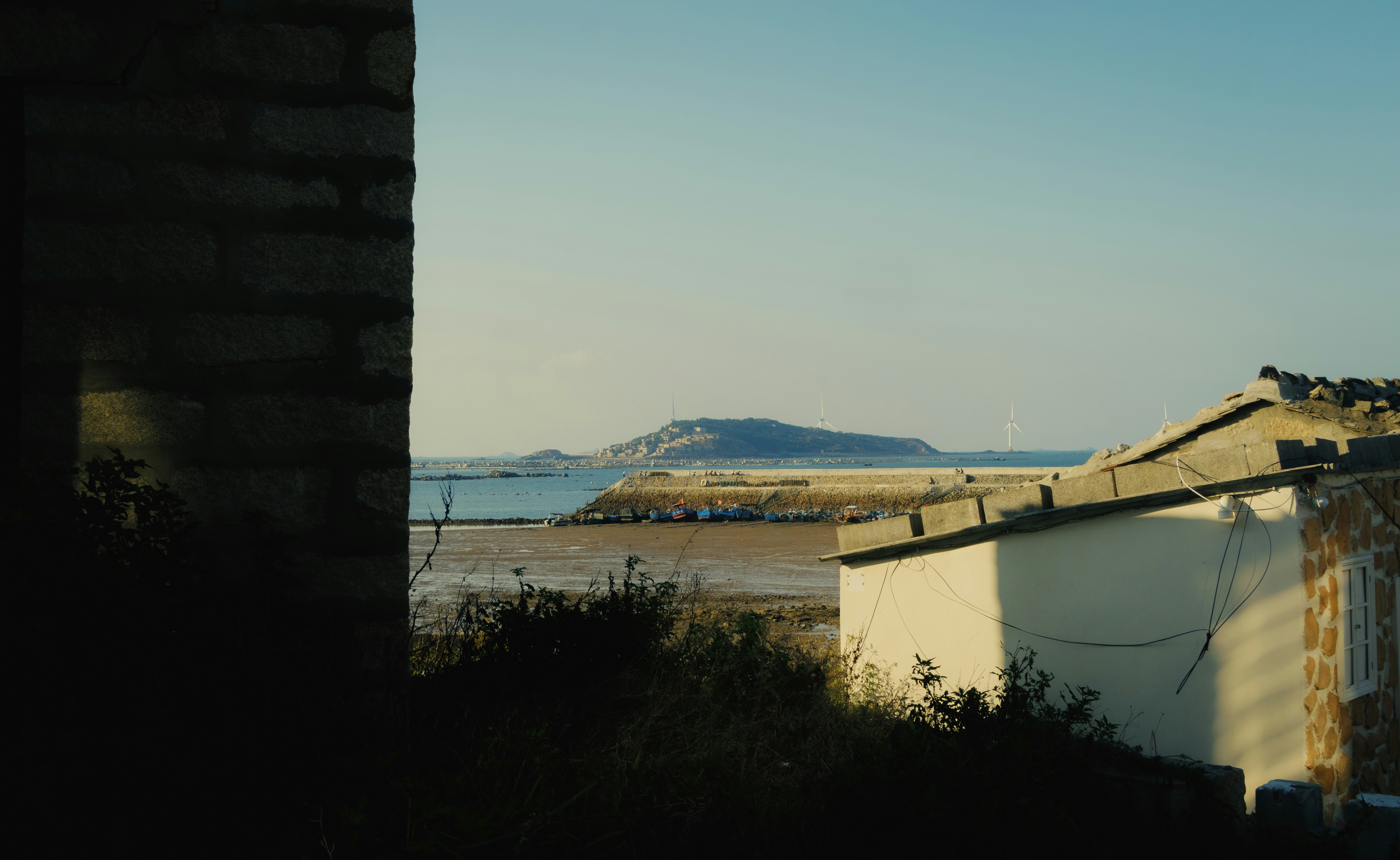 Island and harbor seen through weathered buildings