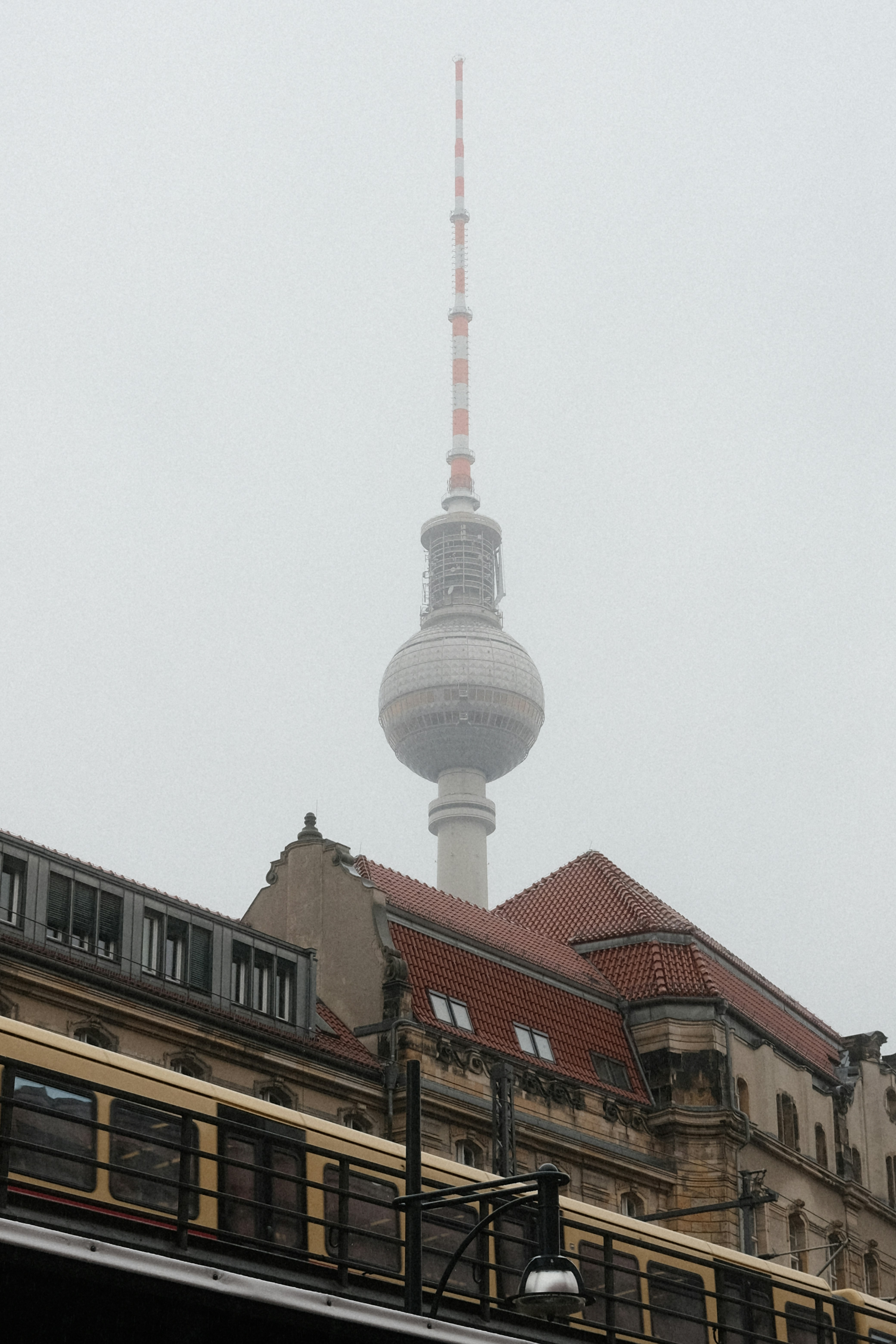 Berlin TV tower behind old buildings and train.