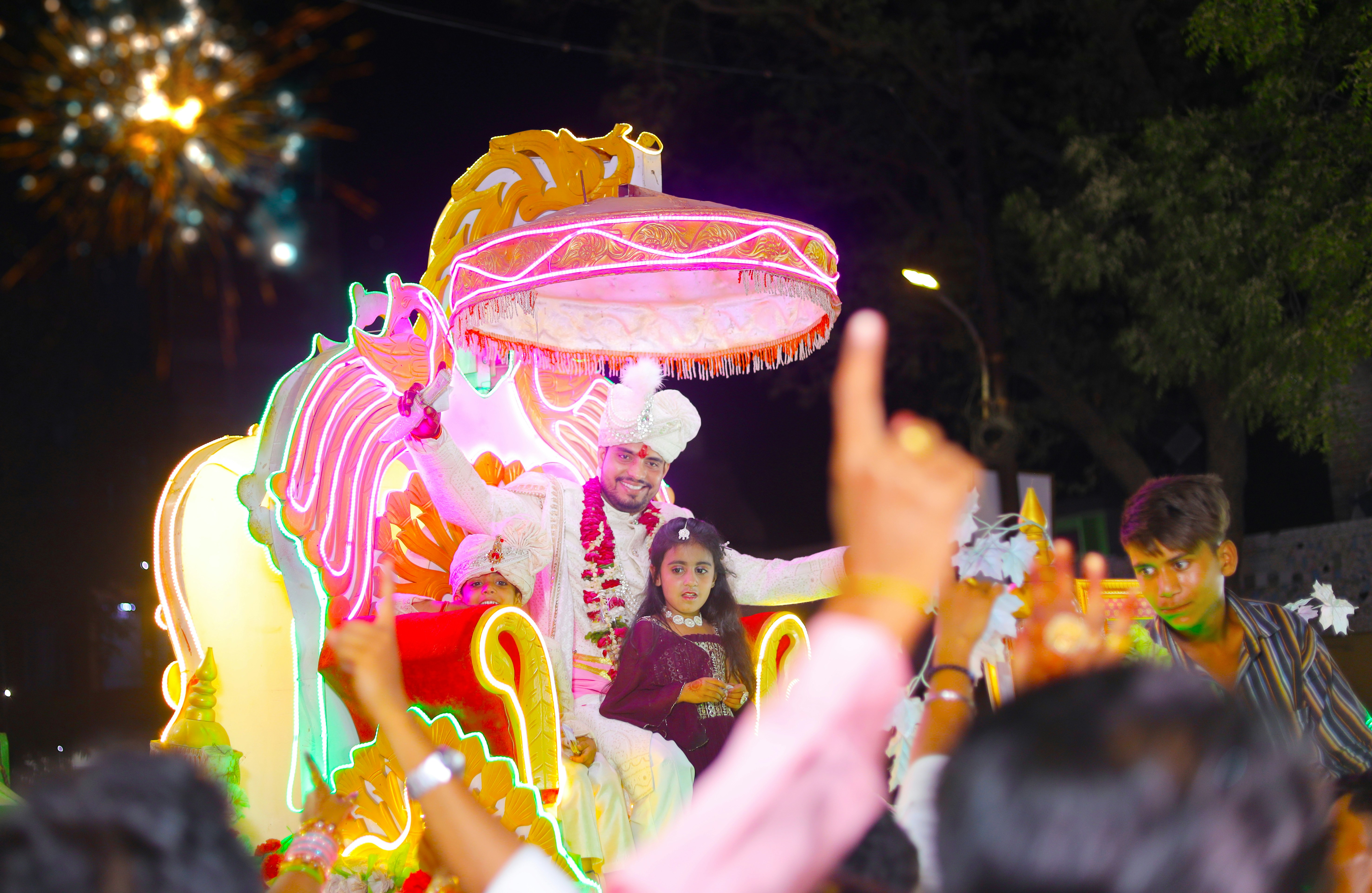 A brightly lit parade float with people watching