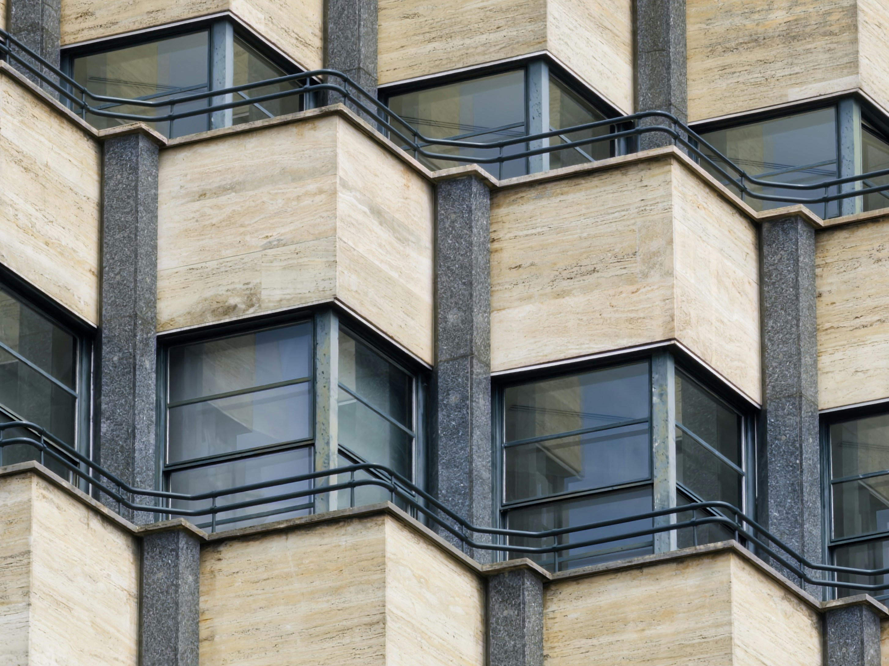 Close-up of a modern building's facade showcasing a rhythmic pattern of windows and textured materials.