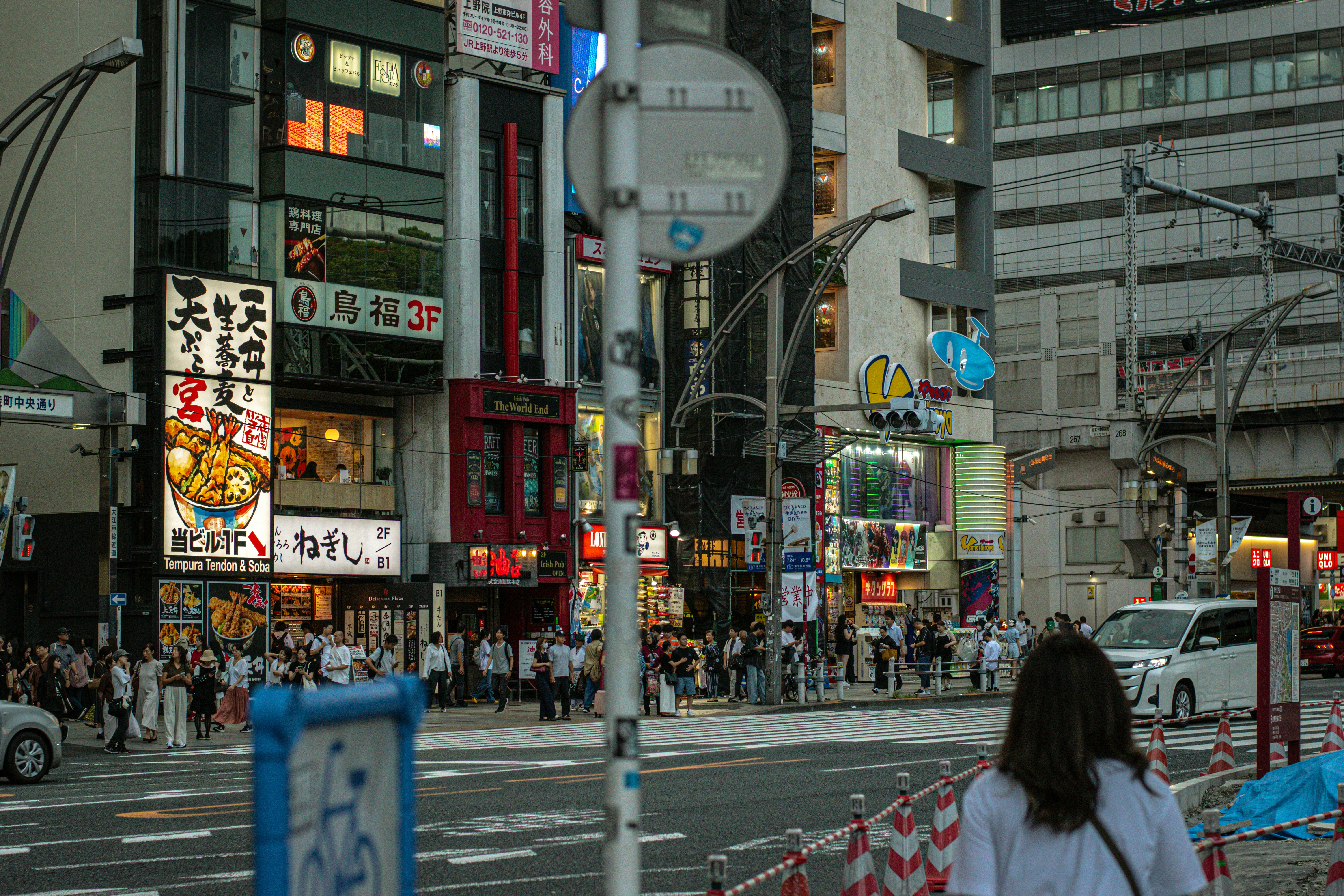 Vibrant street scene featuring illuminated storefronts and bustling pedestrians in an urban setting.