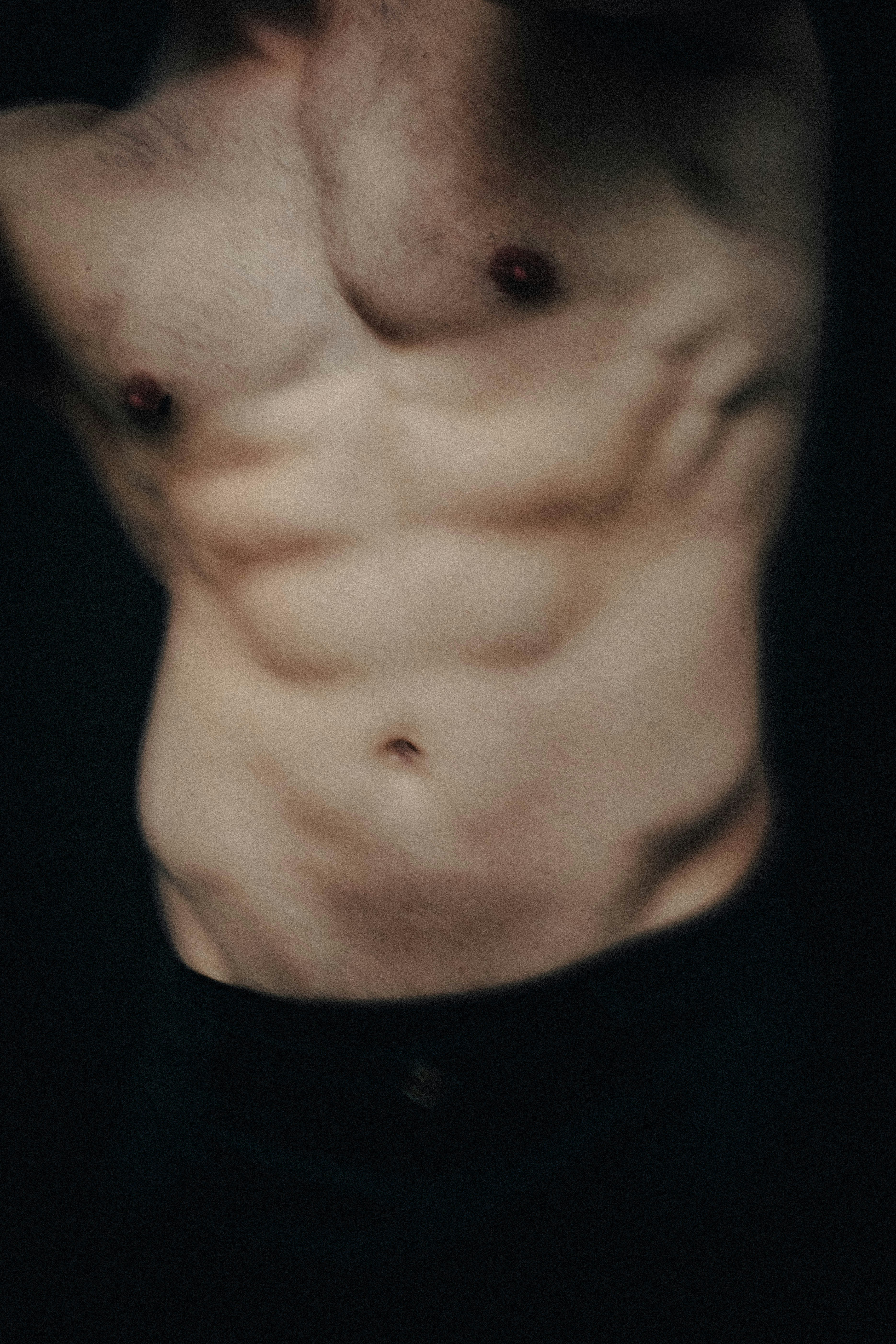 Muscular male torso against a dark background
