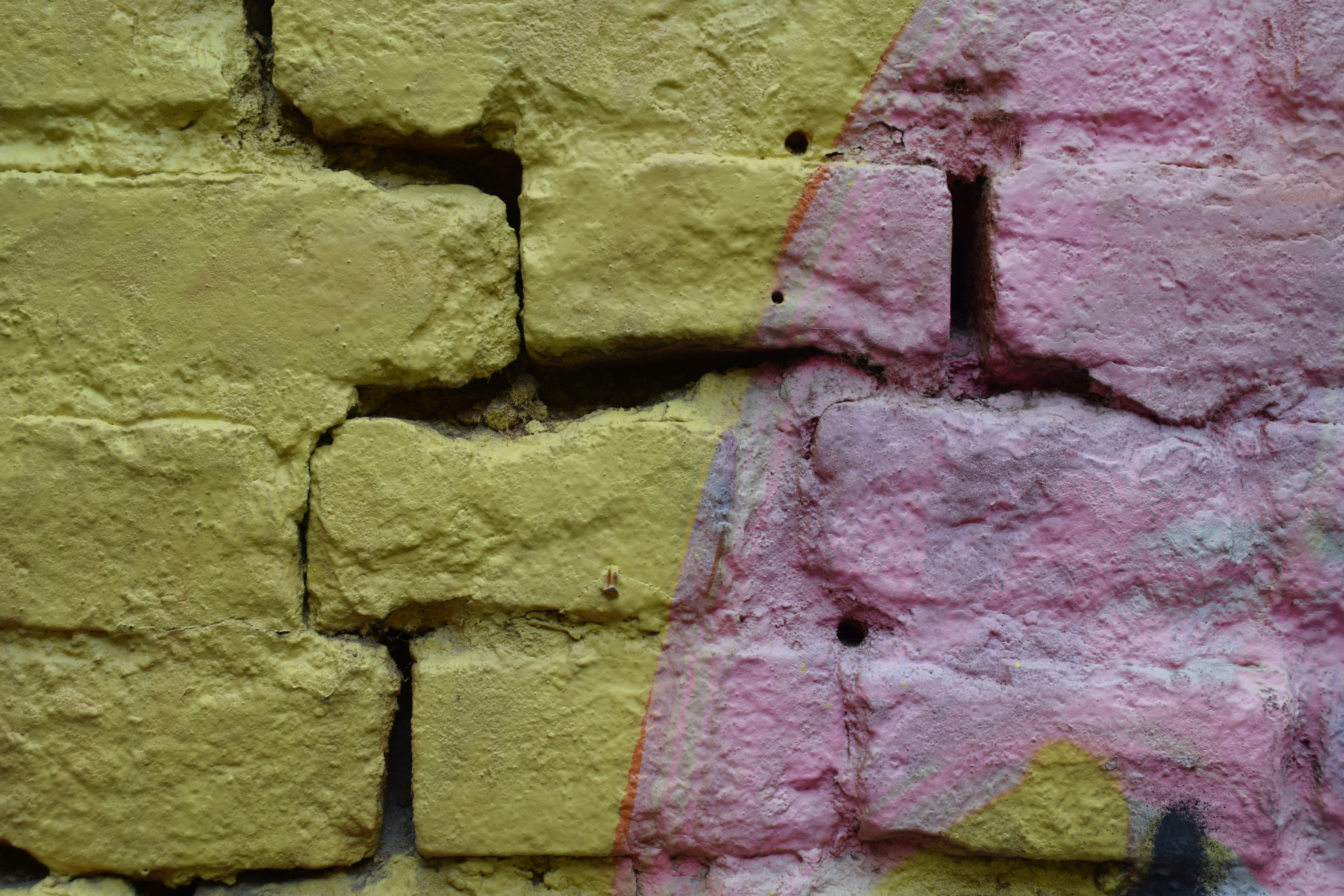 Yellow and pink painted brick wall texture