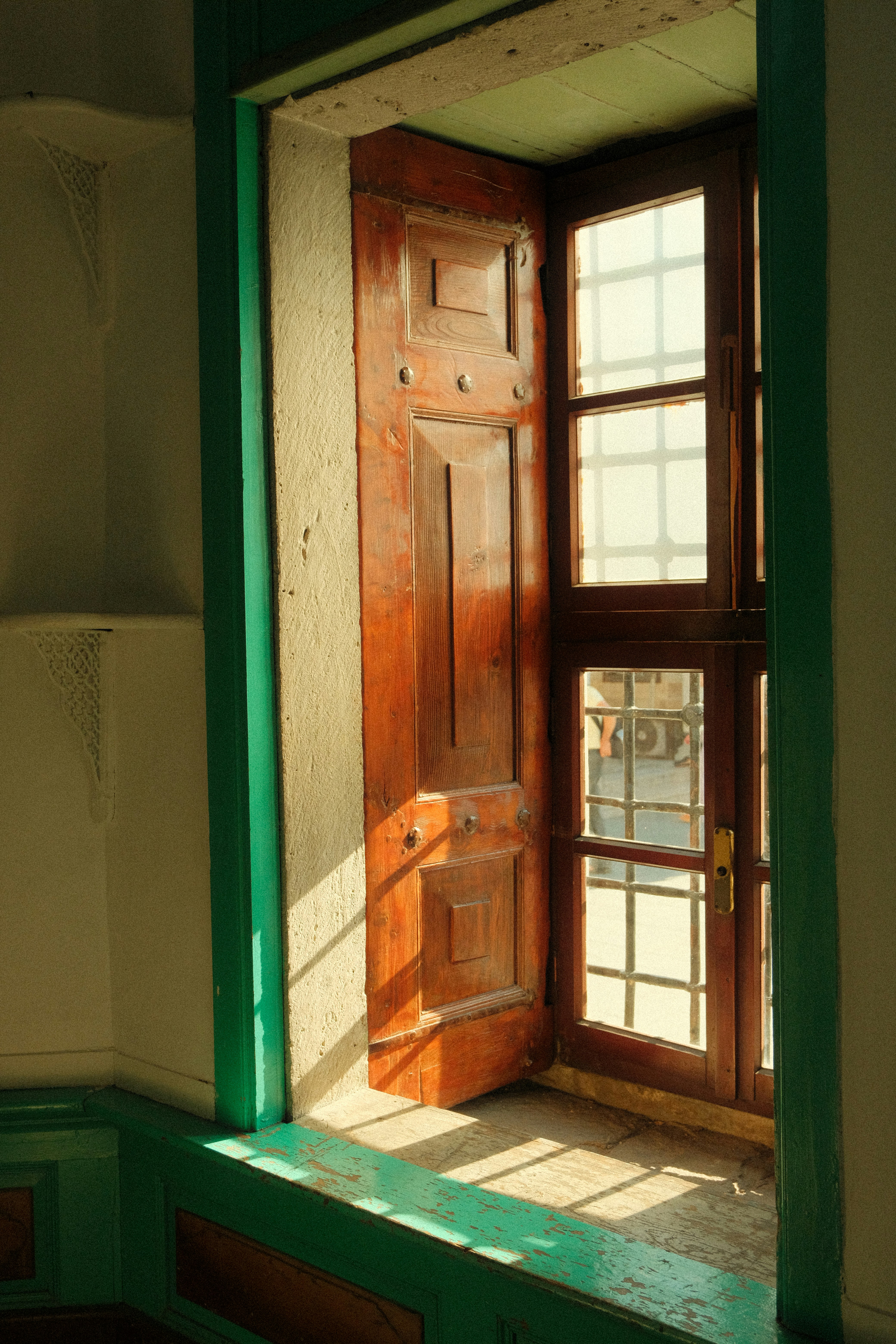 Sunlight streams through a wooden shuttered window.