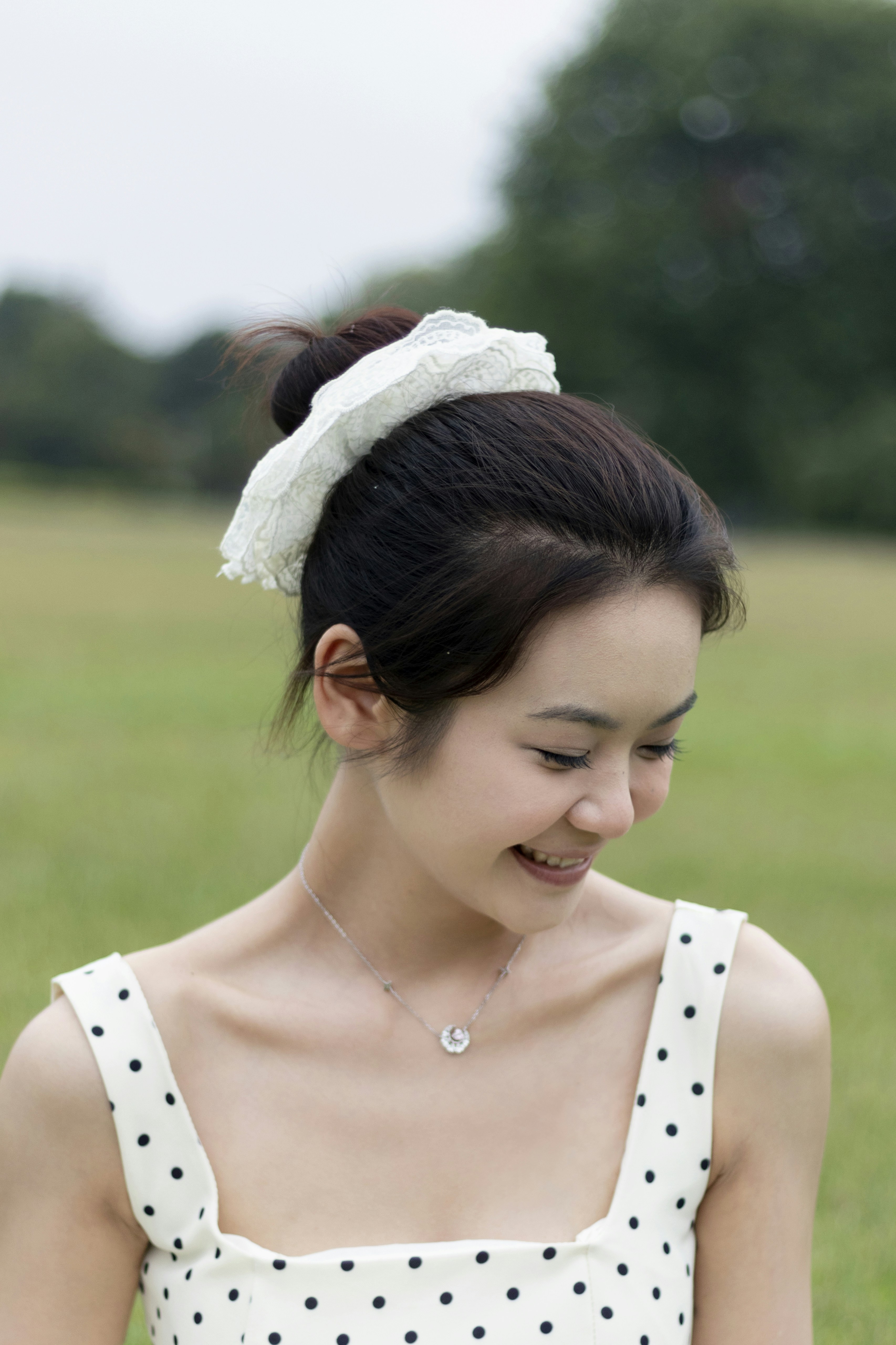 Young woman with a white headband and polka dot dress.